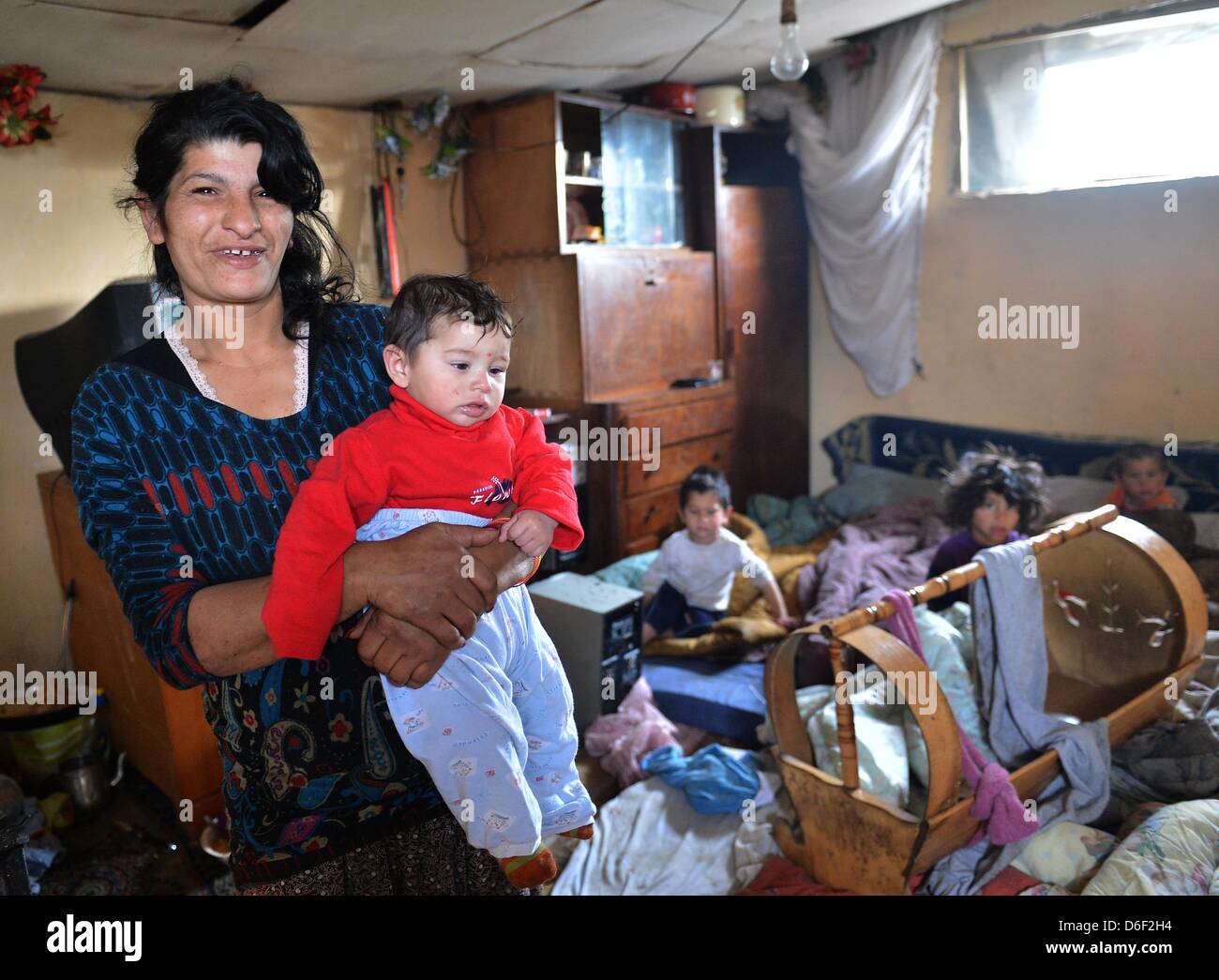 Mother Serjana and her children stand in a room of their makeshift ...