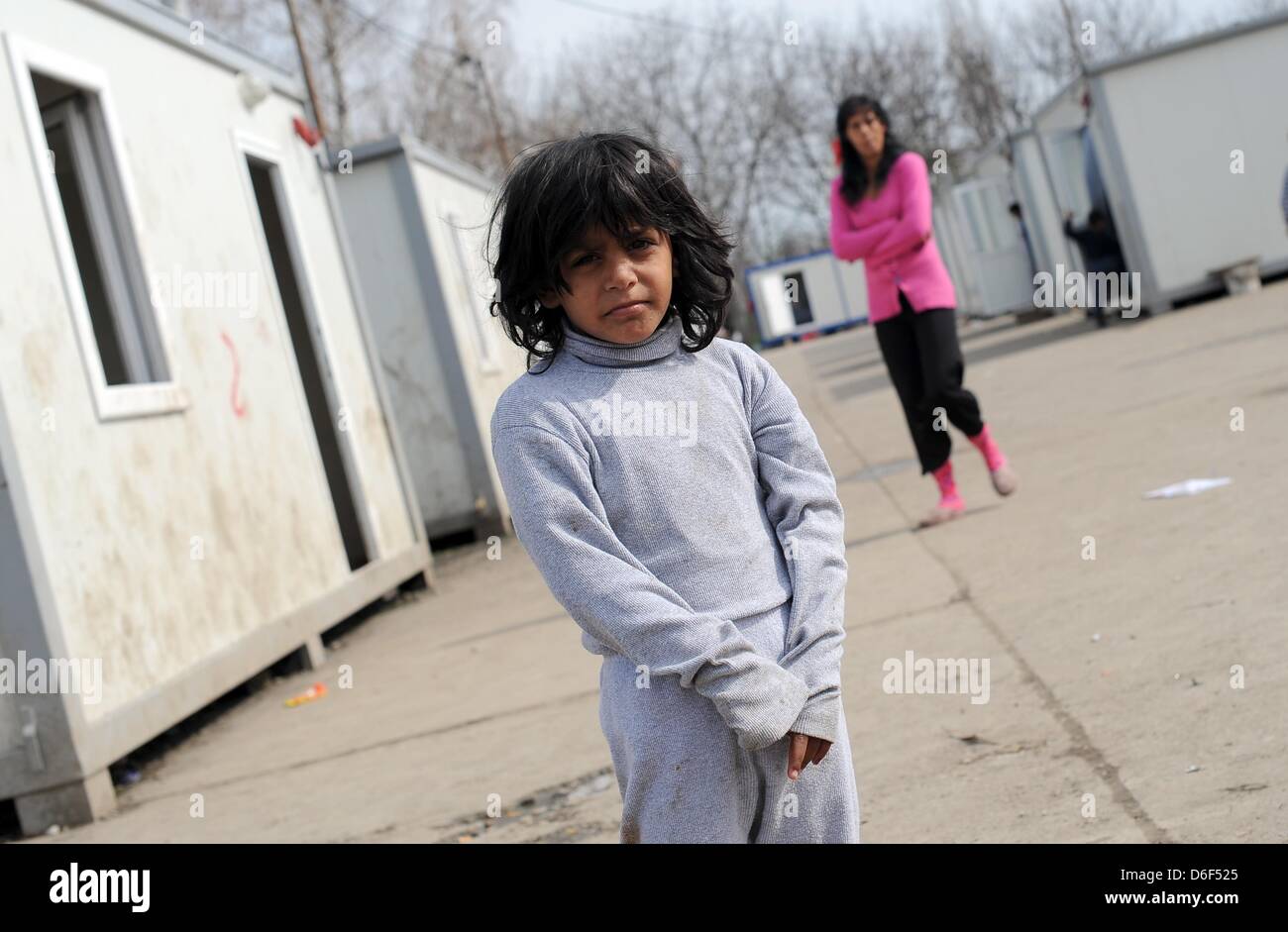 A girl stands between container houses in the Makis settlement, which ...