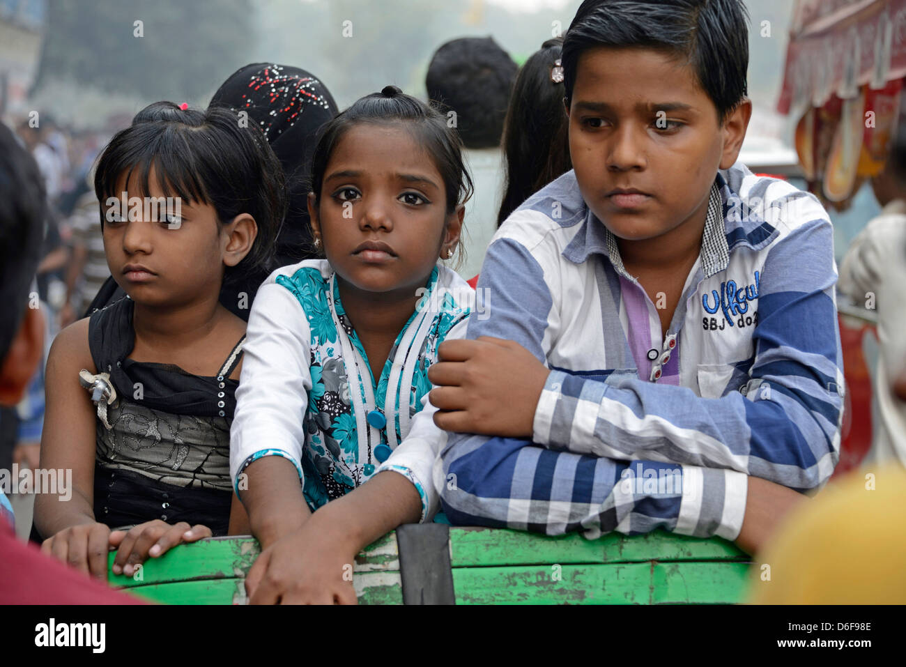 Three children ride on the back of a rickshaw in Old Delhi, India Stock ...