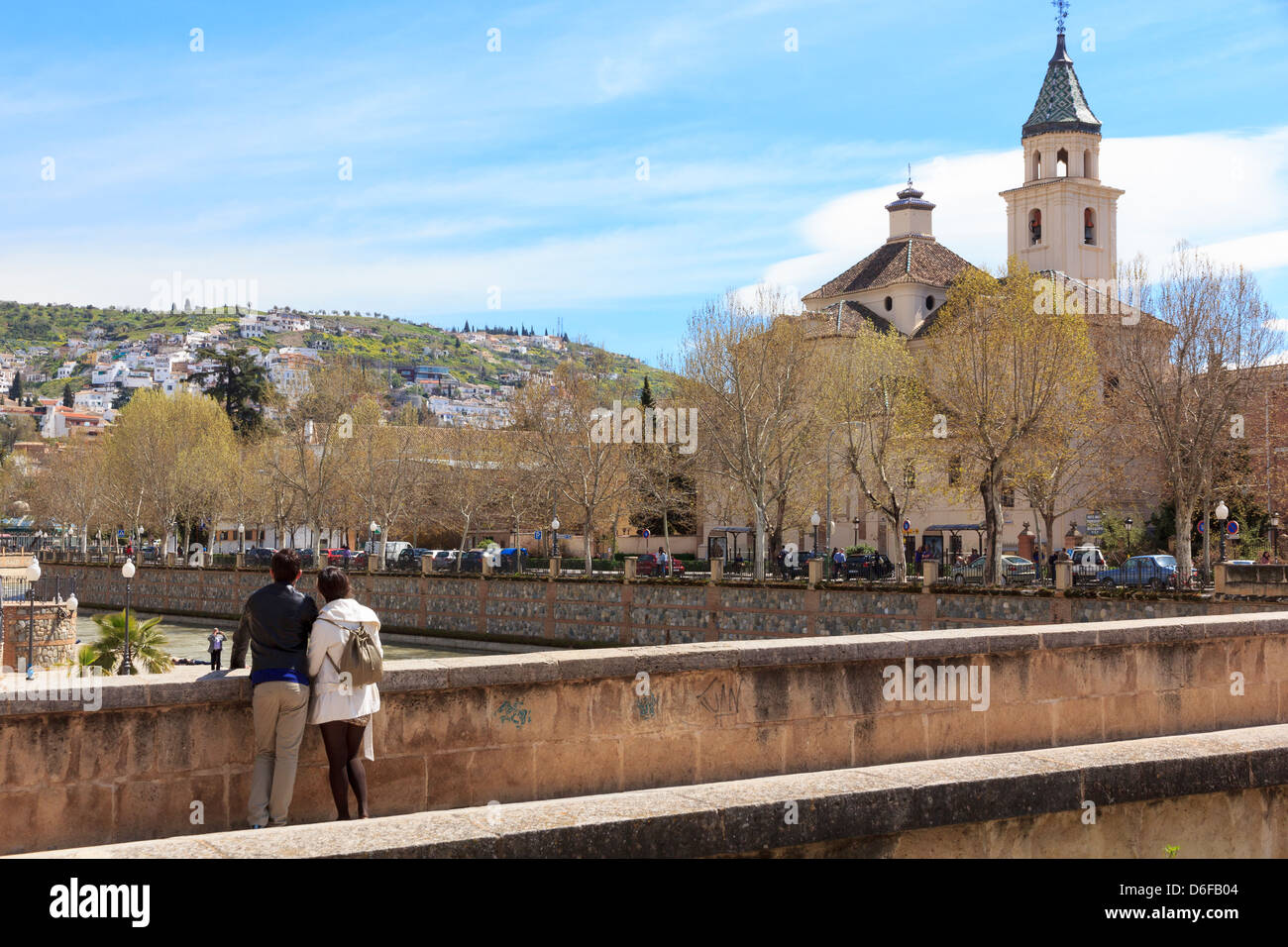 Couple relaxing on a bridge over the Rio Genil, Granada. Monasterio San ...