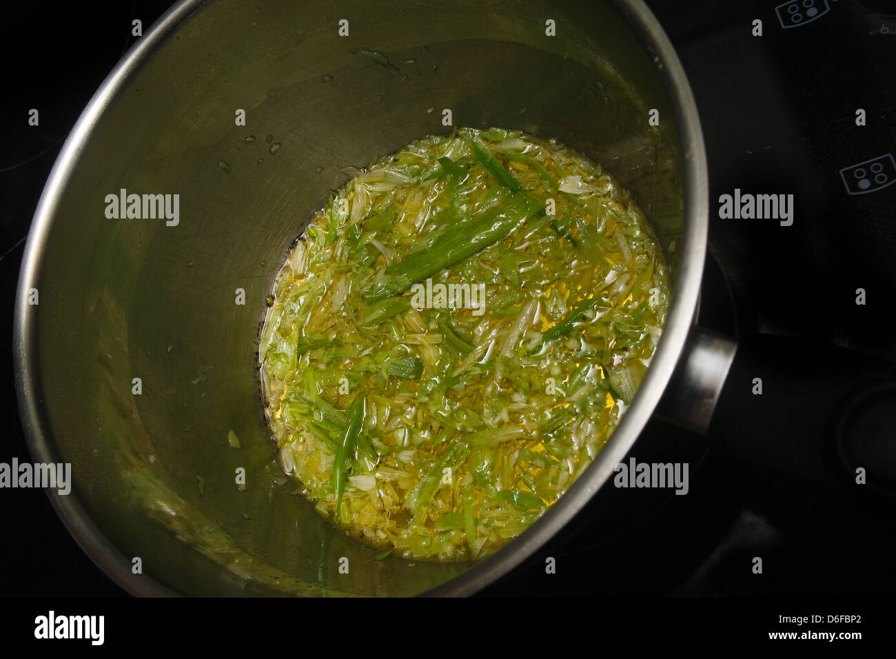 chopped spring onions cooking in vegtable oil in pan Stock Photo - Alamy