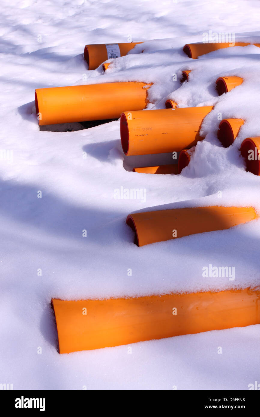 Orange pipes covered in snow Stock Photo - Alamy