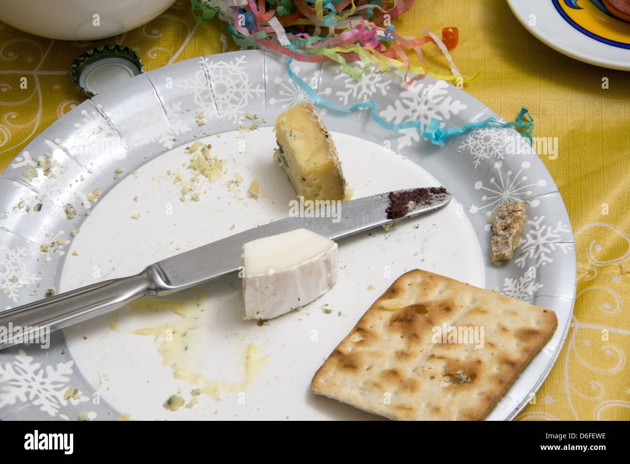 Leftover party food. Bits of cheese and a cream cracker. Food waste ...