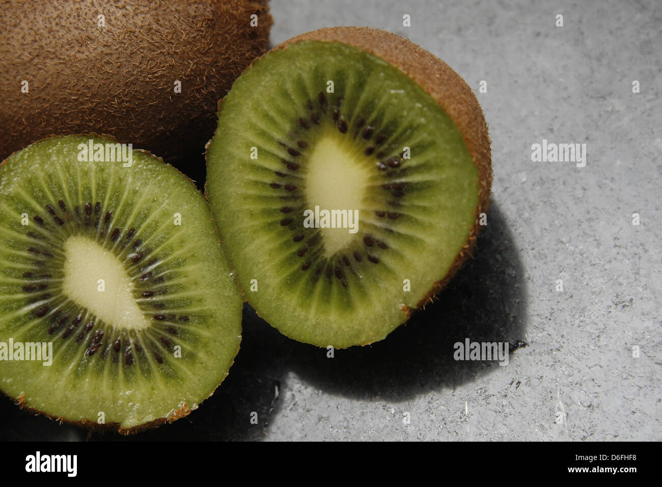 image of cut open kiwi on marble chopping board Stock Photo - Alamy