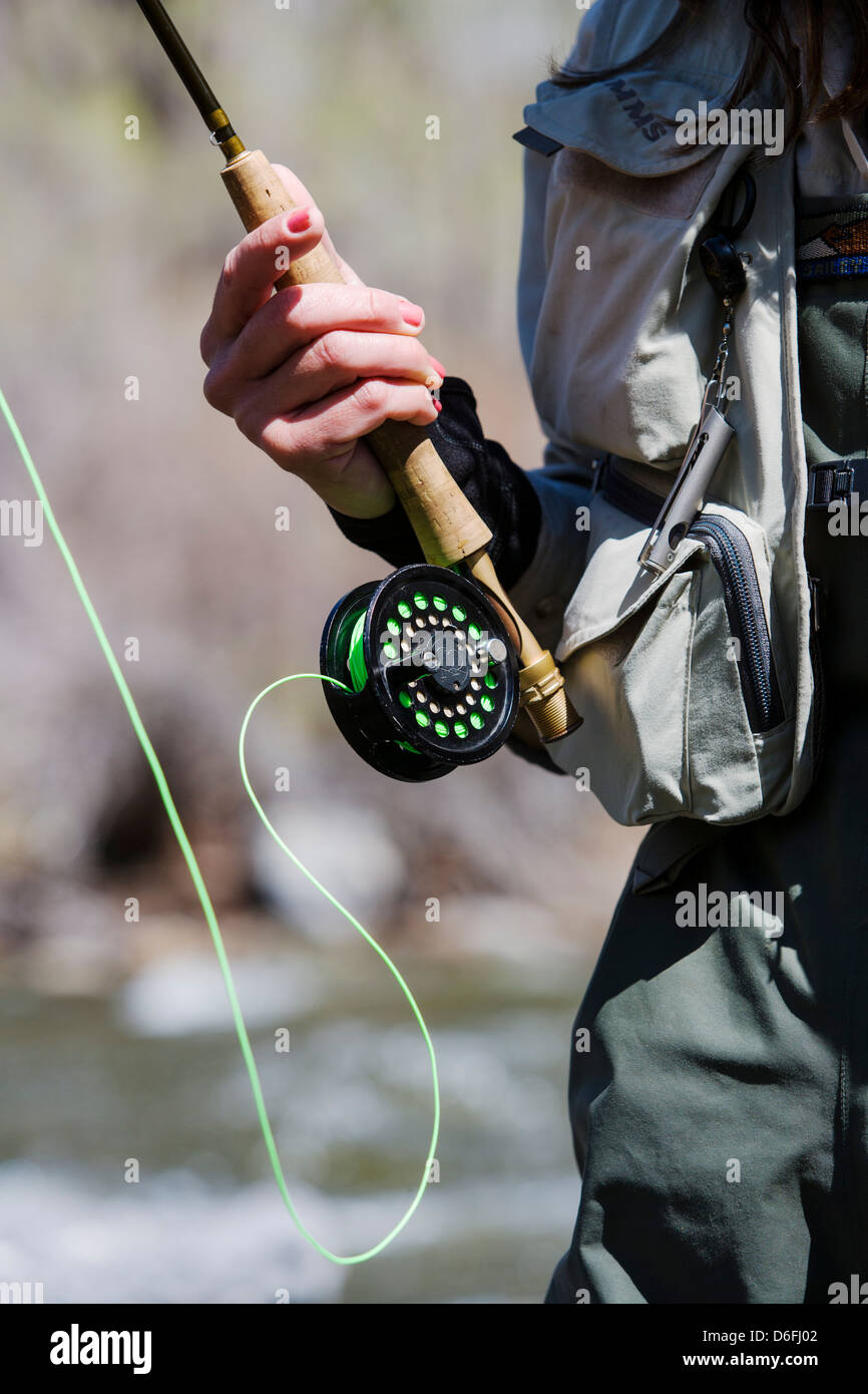 Close up of rod and reel held by woman fly fishing the Arkansas River ...