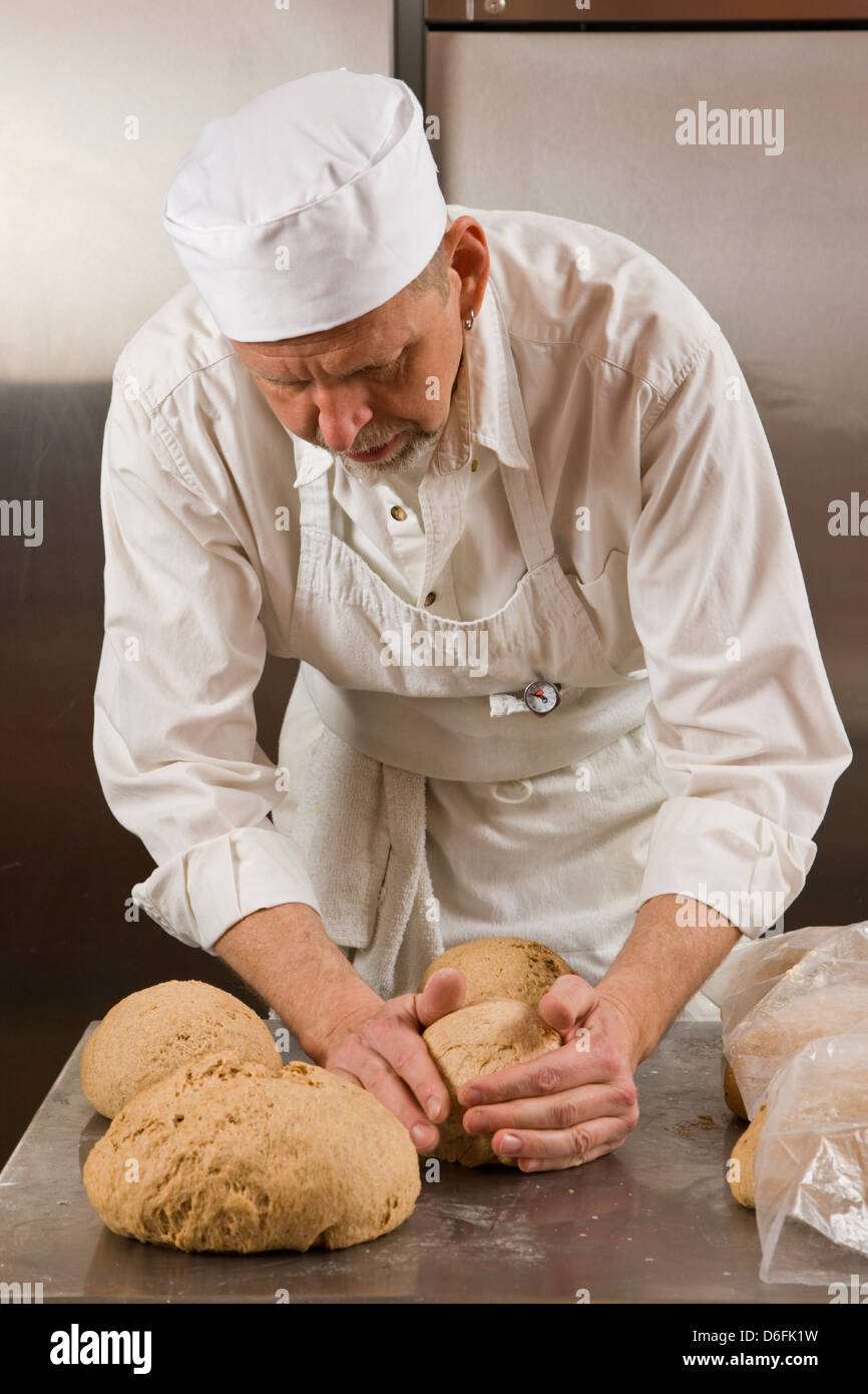 Professional cook preparing fresh bread in a commercial bakery Stock ...