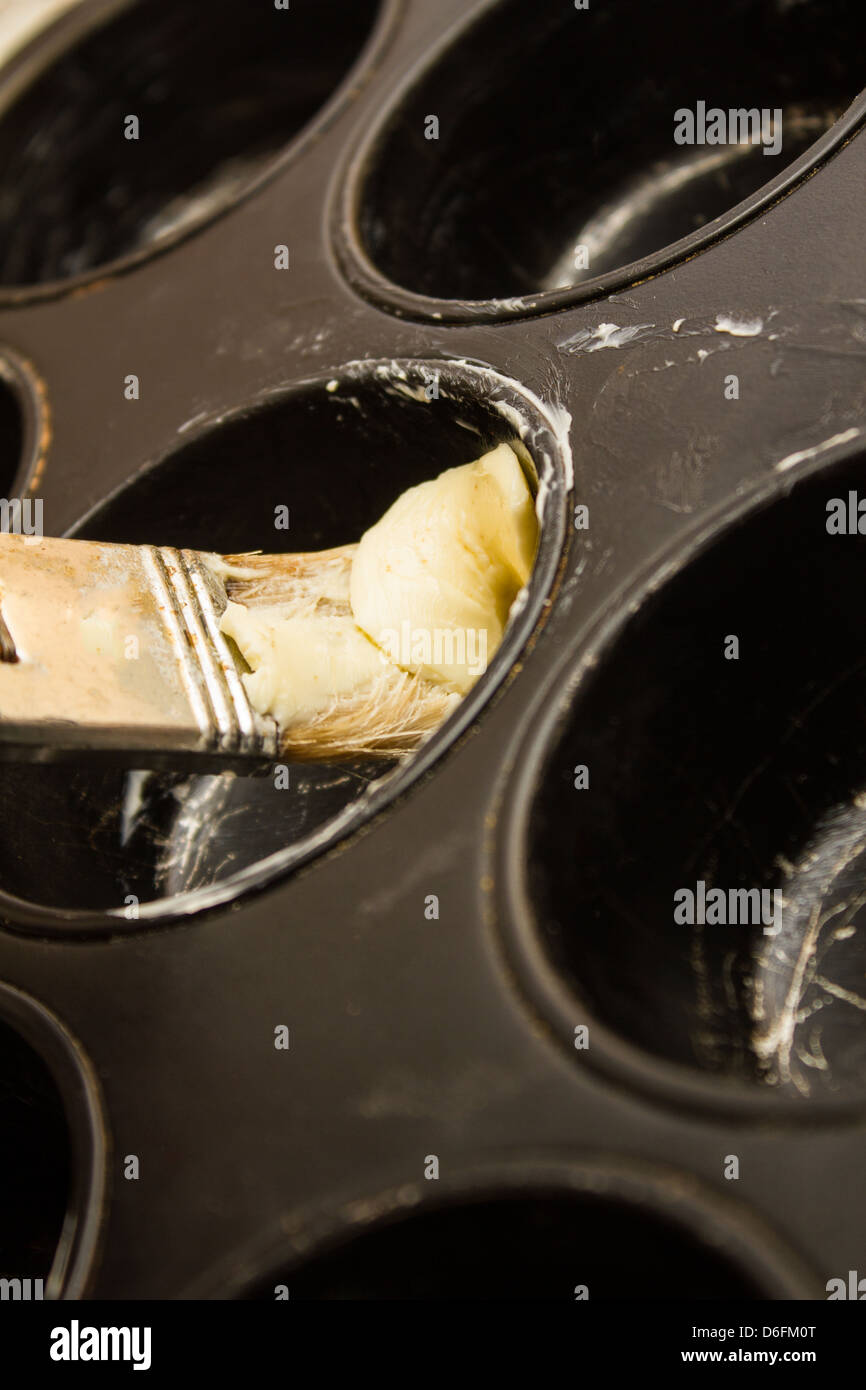 greasing the muffin baking form Stock Photo - Alamy