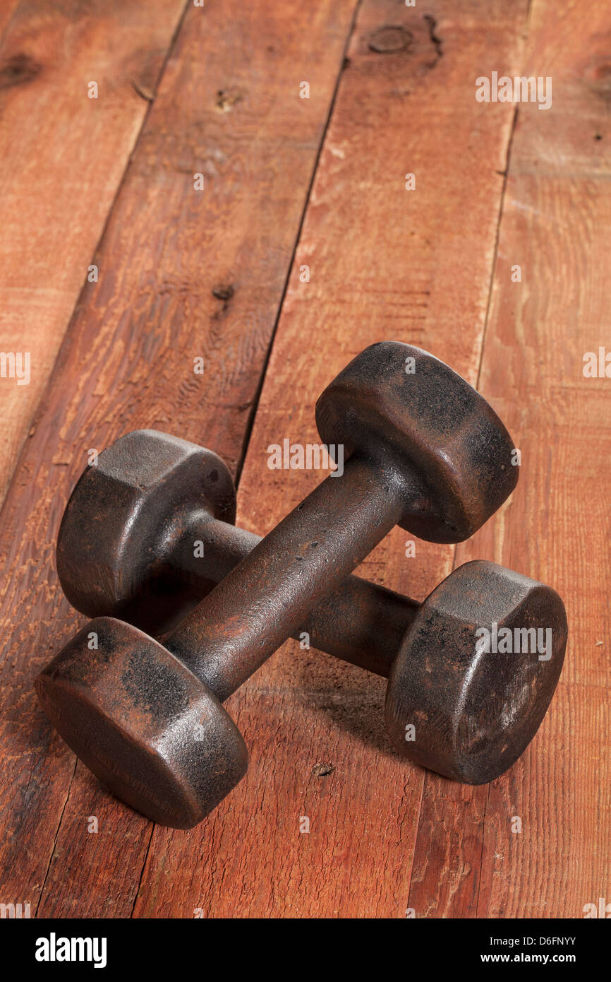 a pair of vintage iron rusty dumbbells on red barn wood background ...