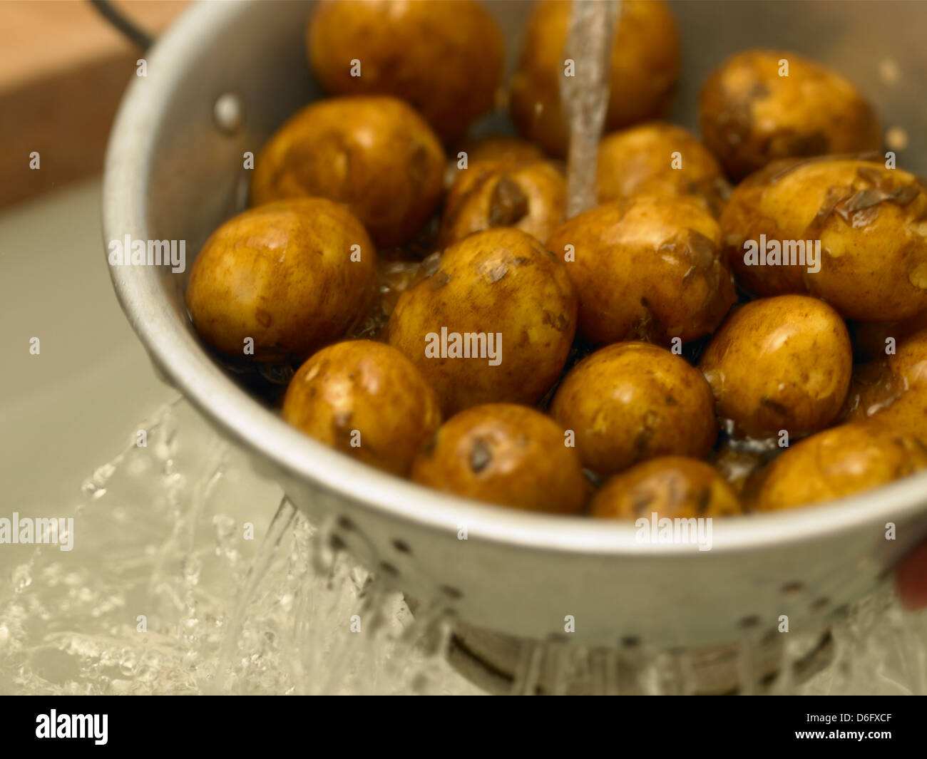 New potatoes washing in colander Stock Photo - Alamy