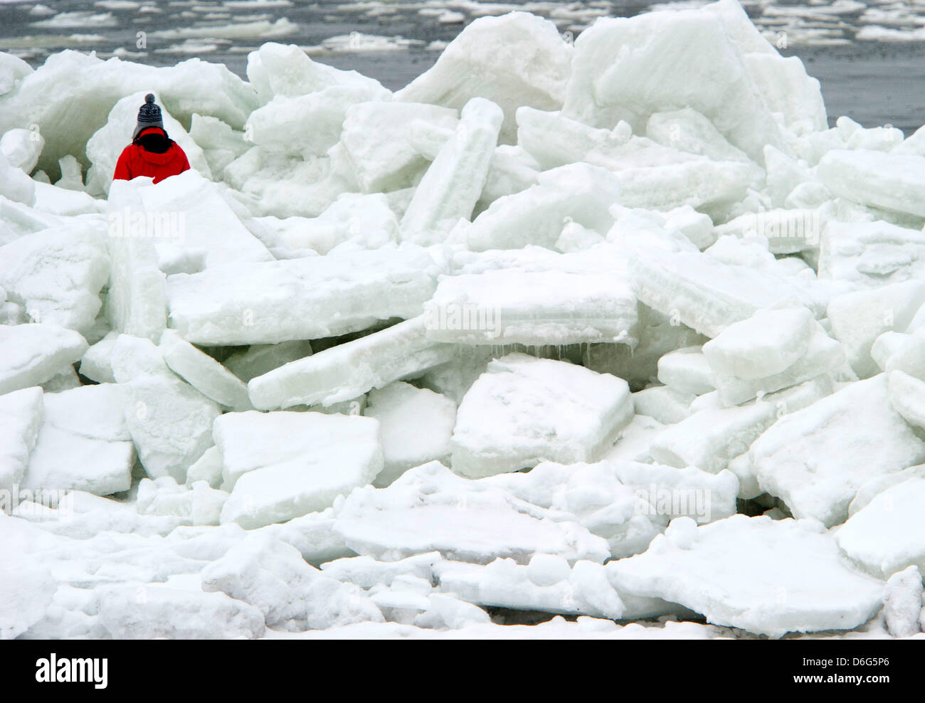 A woman climbes through a bizarre landscape of piled up sheets of ice ...