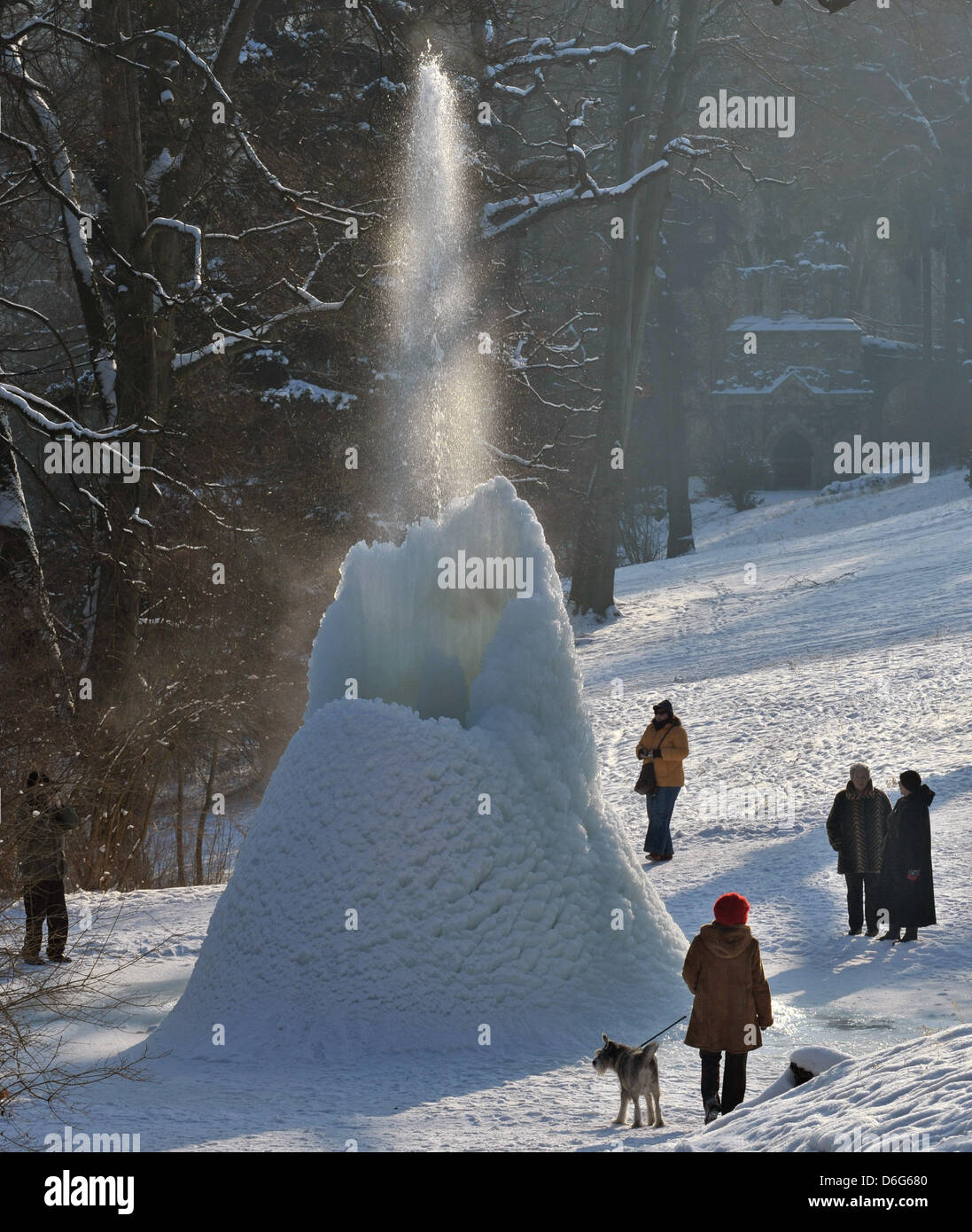 The water from the a fountain shoots up and forms a cone of ice in the ...