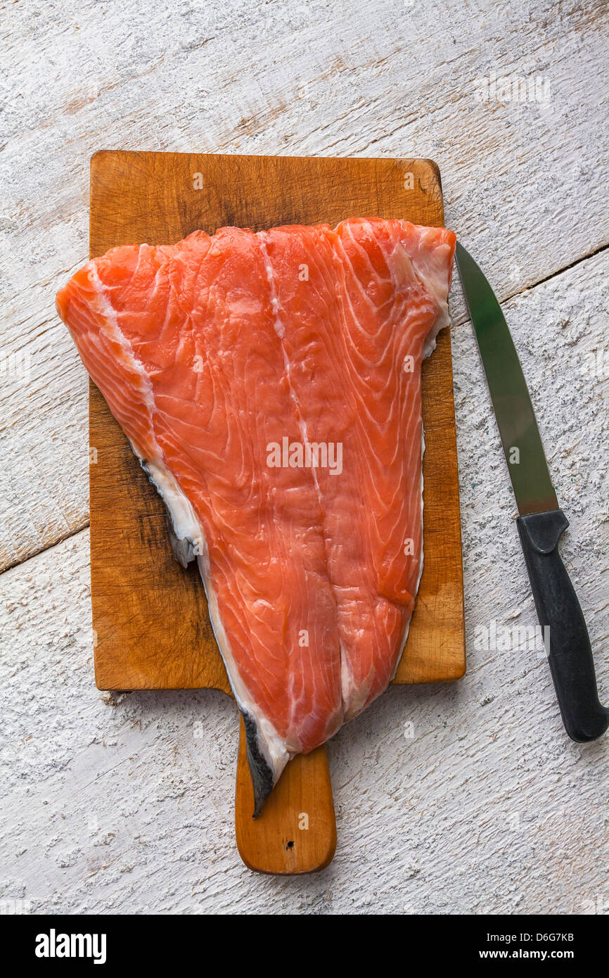 Salmon raw fish on chopping board on white wooden background Stock ...