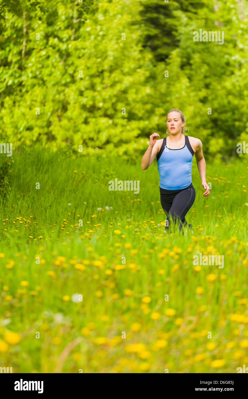 Caucasian woman running in tall grass Stock Photo - Alamy