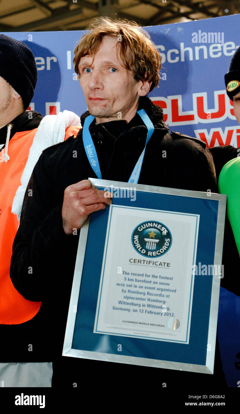 Kai Martin shows his certificate after finishing his 5,000 meters ...