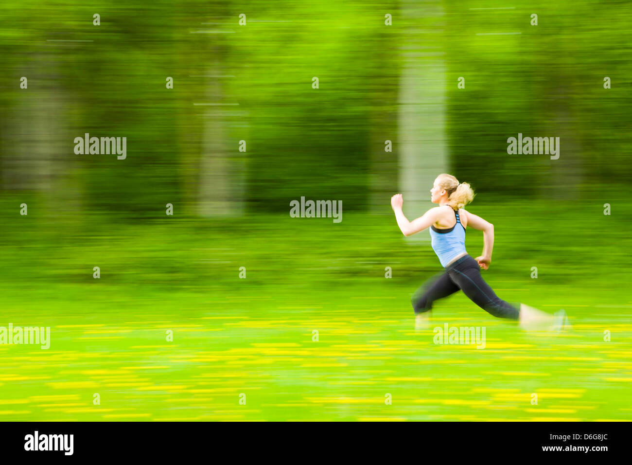 Blurred view of Caucasian woman running in tall grass Stock Photo - Alamy