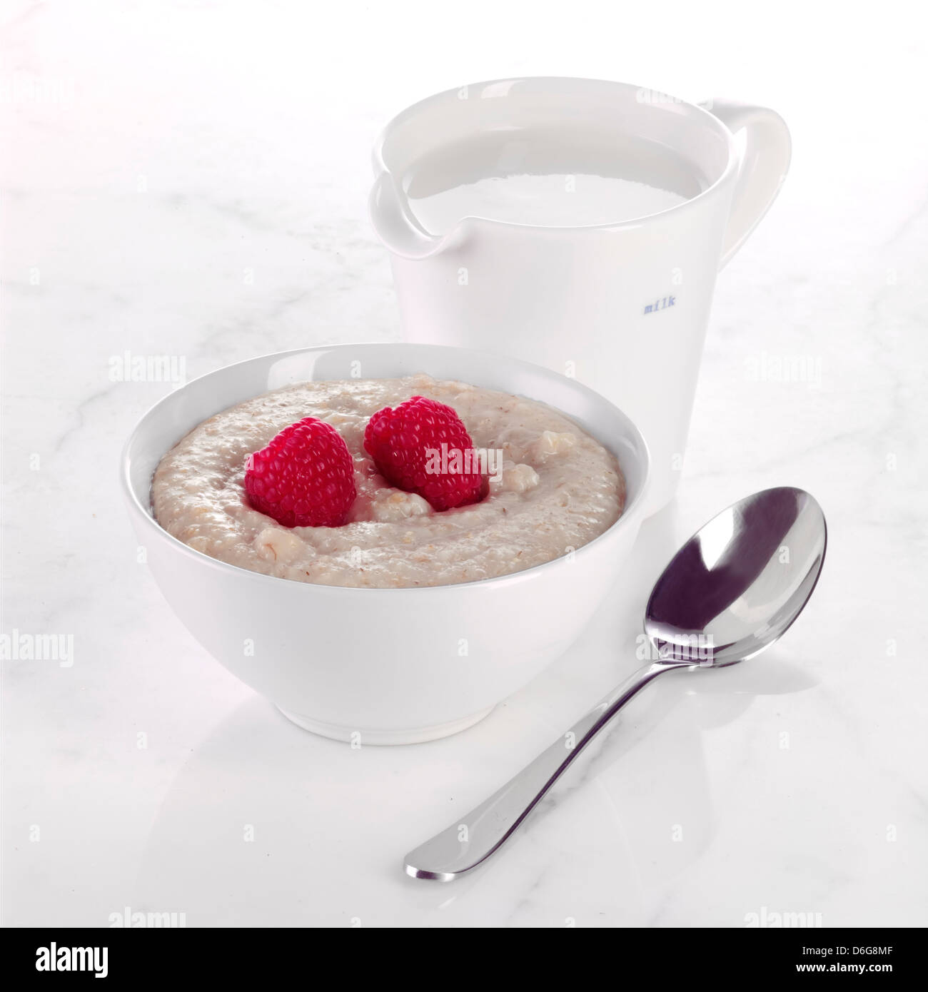 Porridge with Raspberries and a Jug of Milk Stock Photo - Alamy