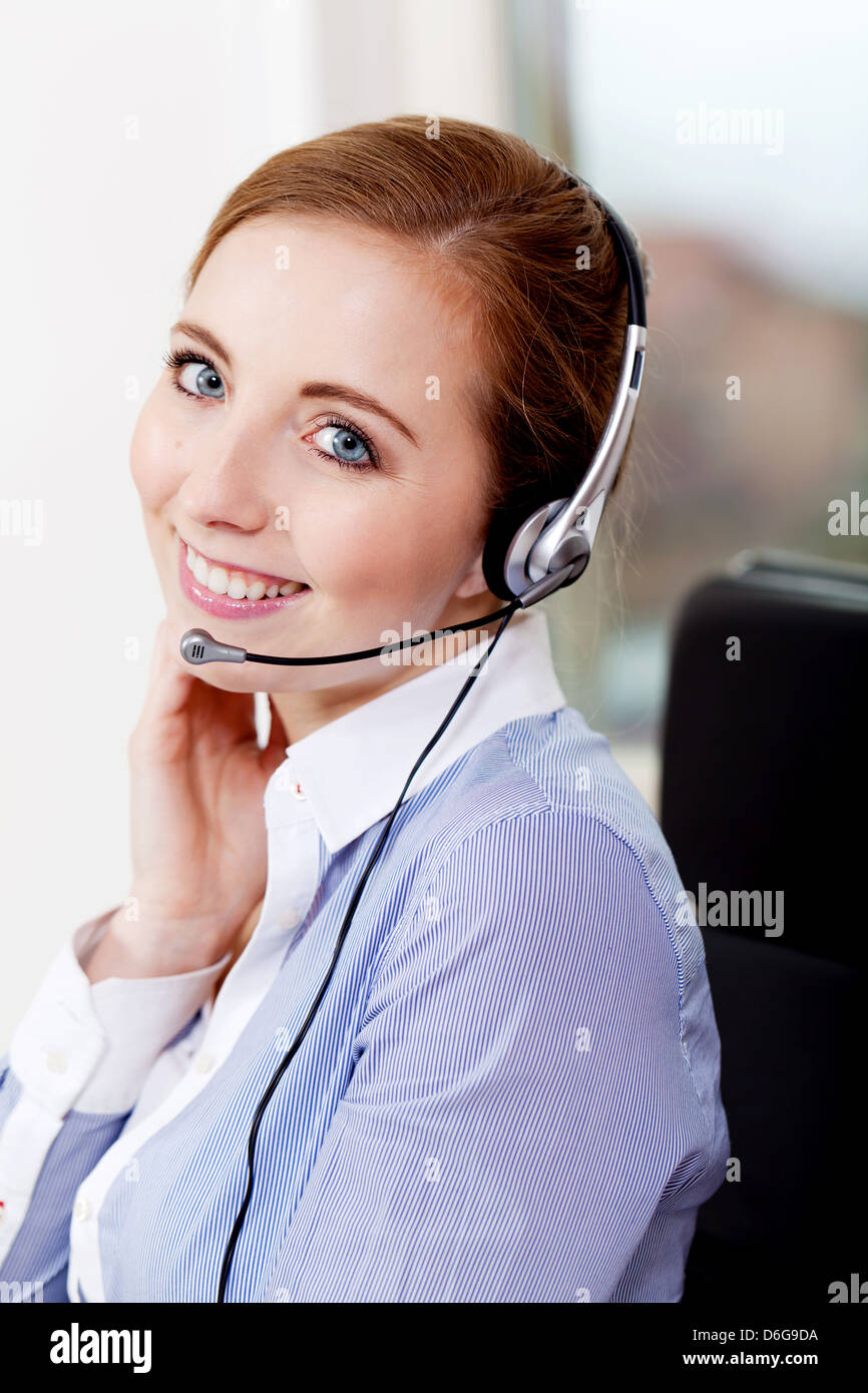 smiling young female callcenter agent with headset Stock Photo - Alamy