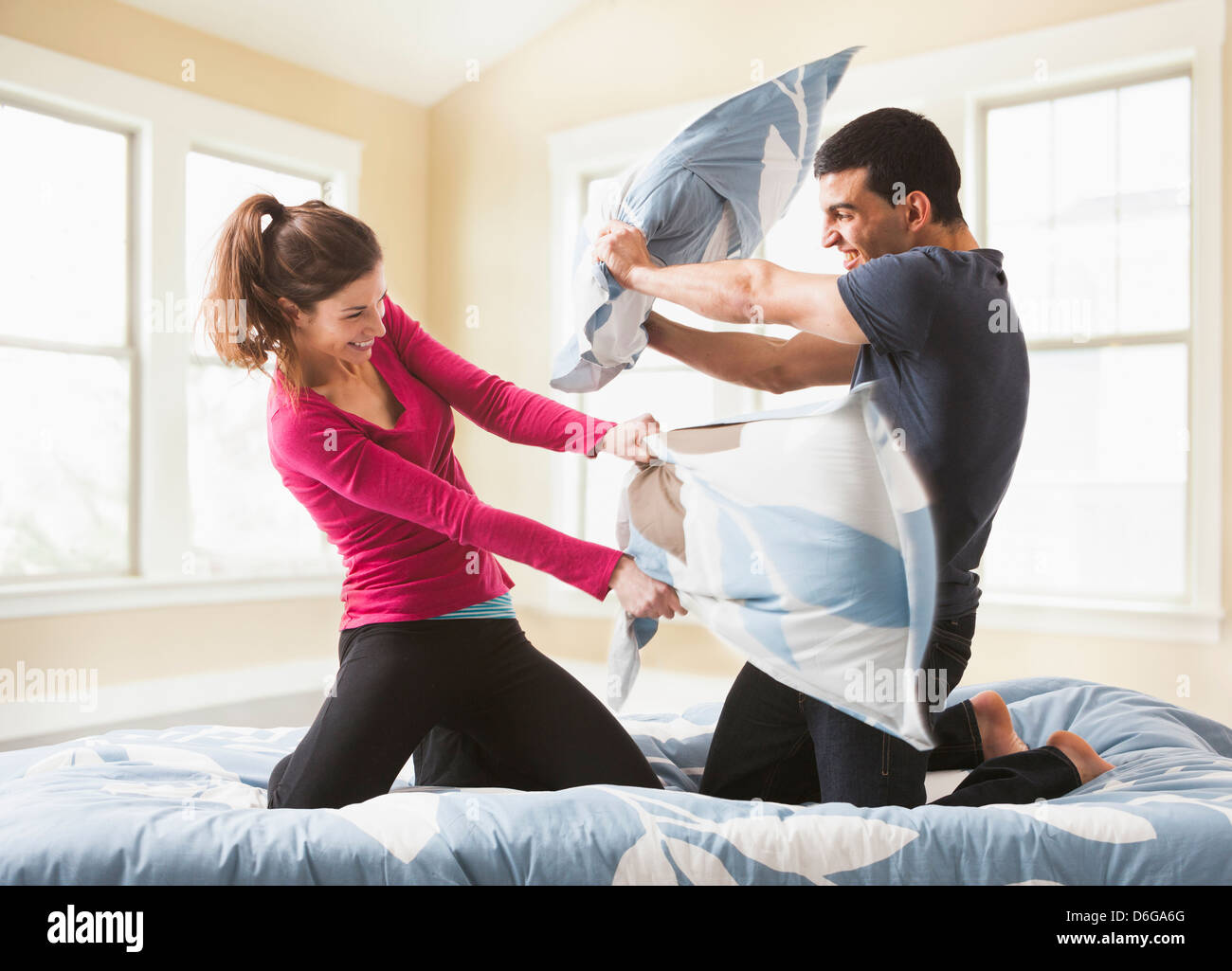 Couple having pillow fight on bed Stock Photo - Alamy