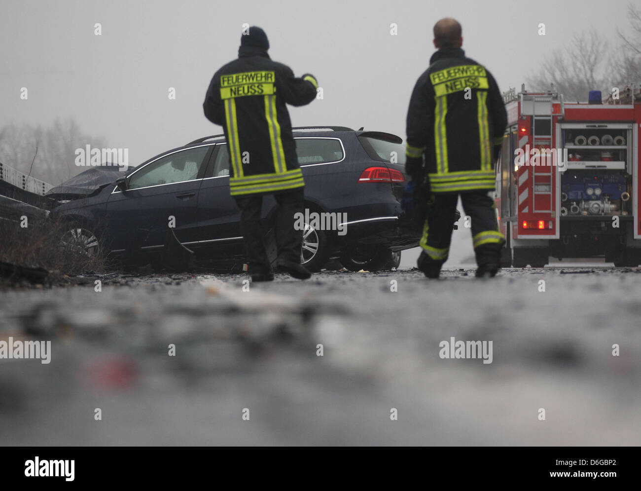 Firefighters look at a car wreck on the autobahn A 57 near Dormagen ...