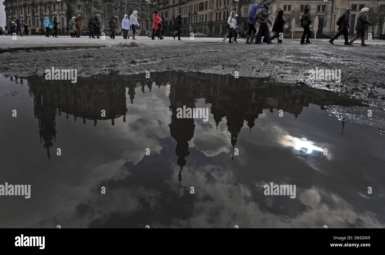 The silhouette of Dresden is reflected in a puddle of water, created by ...