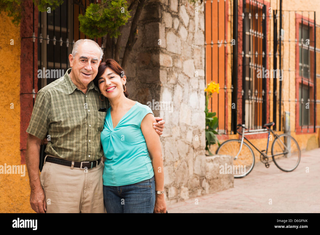 Hispanic couple smiling on city street Stock Photo - Alamy