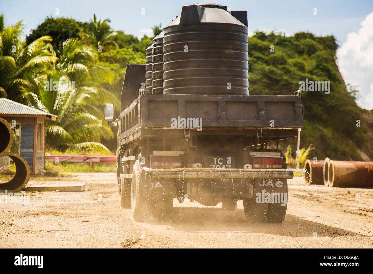 Truck carrying barrels on dirt road Stock Photo - Alamy