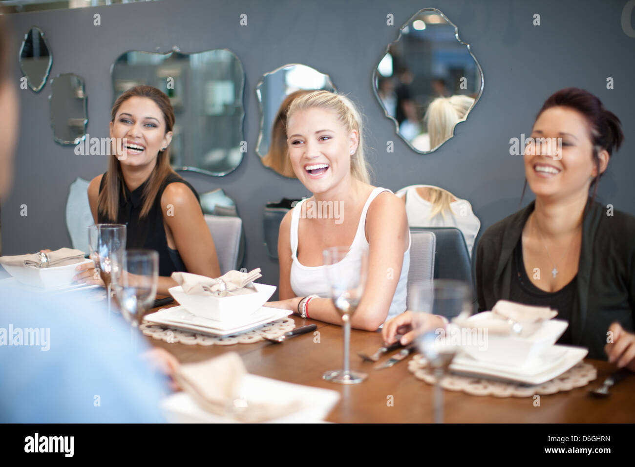 Women laughing at dinner table Stock Photo - Alamy