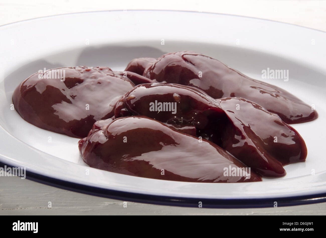 raw chicken liver on a white and blue plate Stock Photo - Alamy