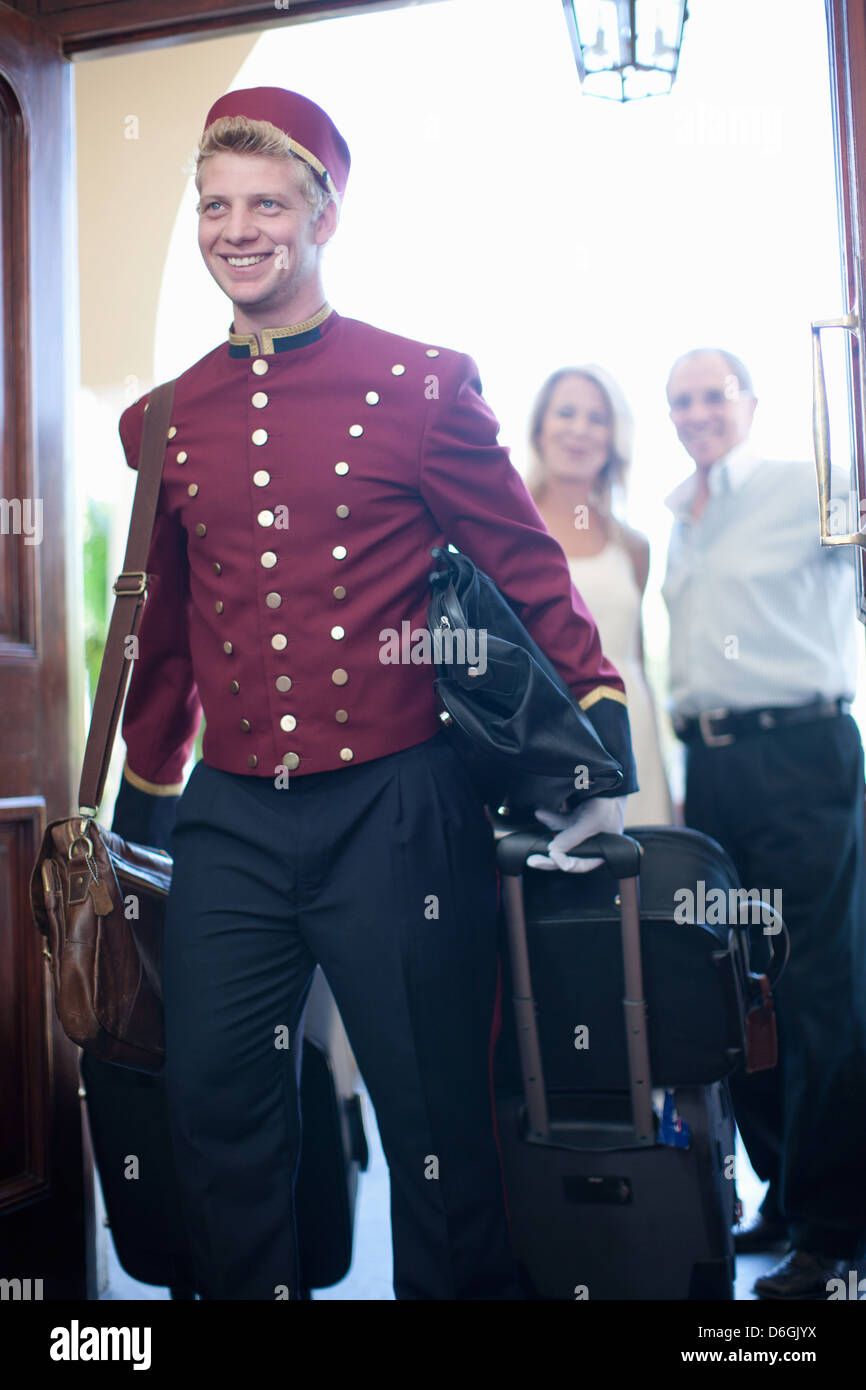 Bellhop carrying luggage in hotel Stock Photo - Alamy