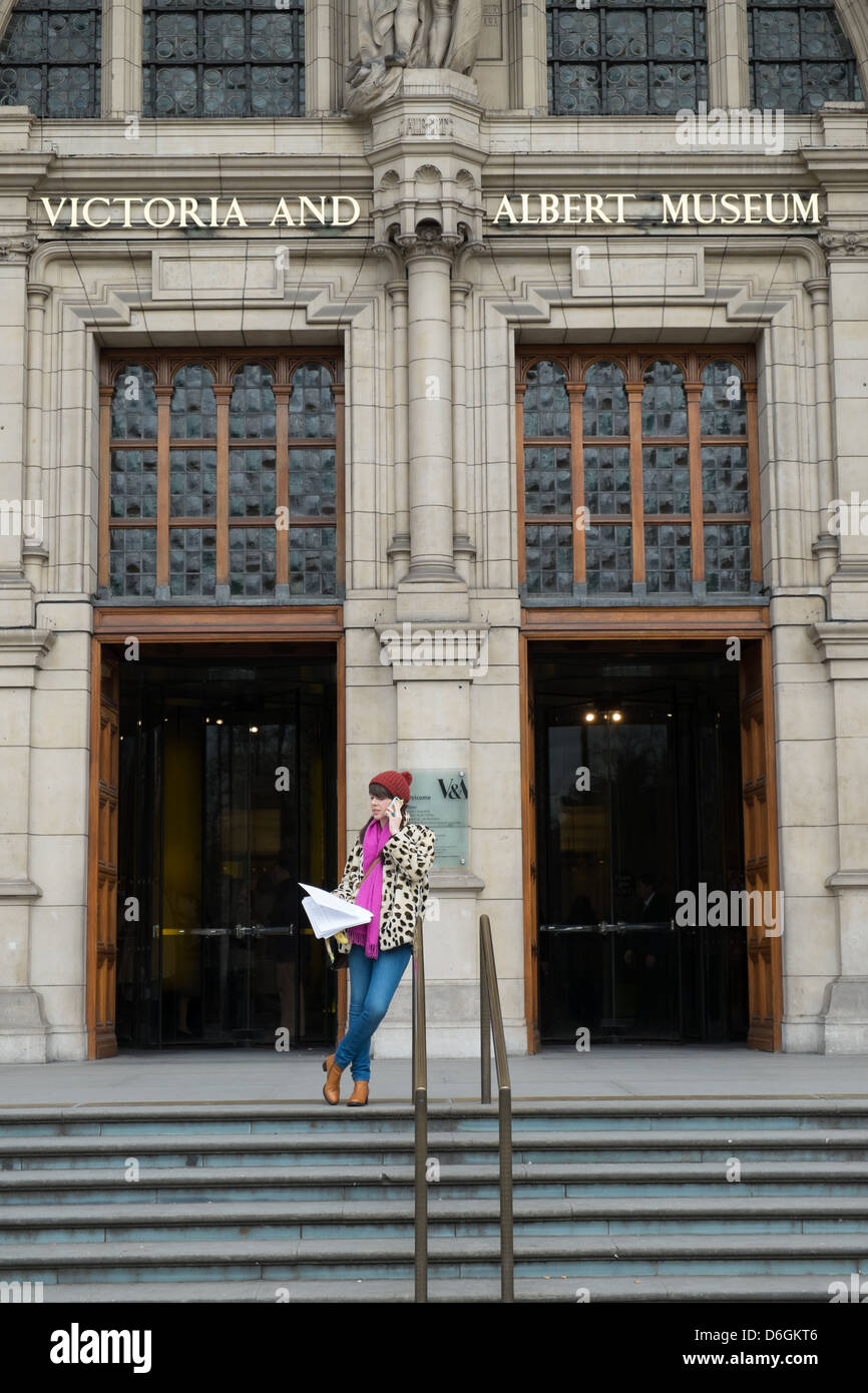 A young woman using a mobile phone on the steps of the Victoria and ...