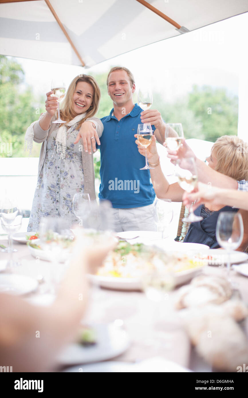 Couple making toast at table Stock Photo - Alamy