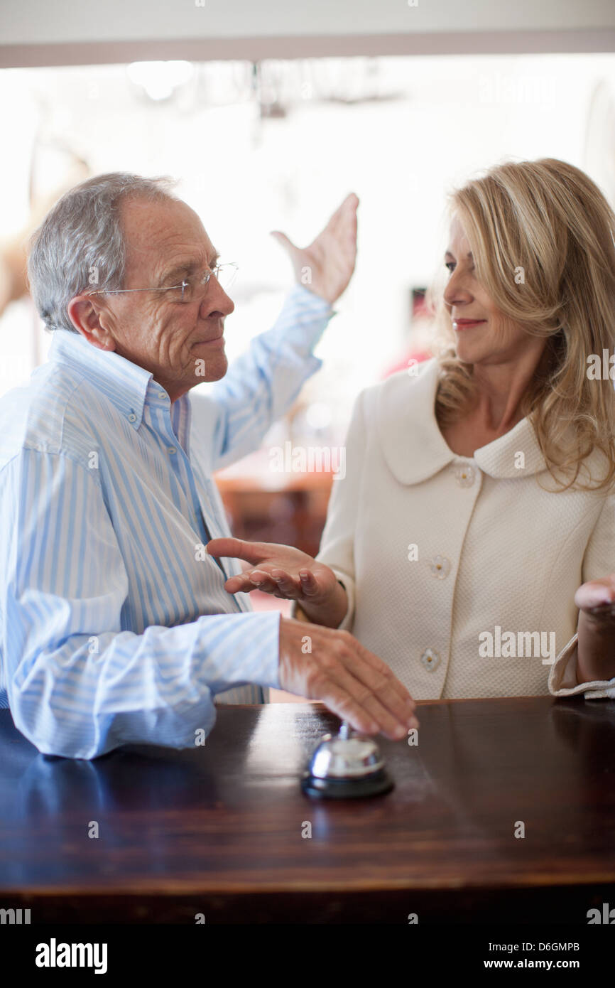 Couple ringing bell in hotel lobby Stock Photo - Alamy