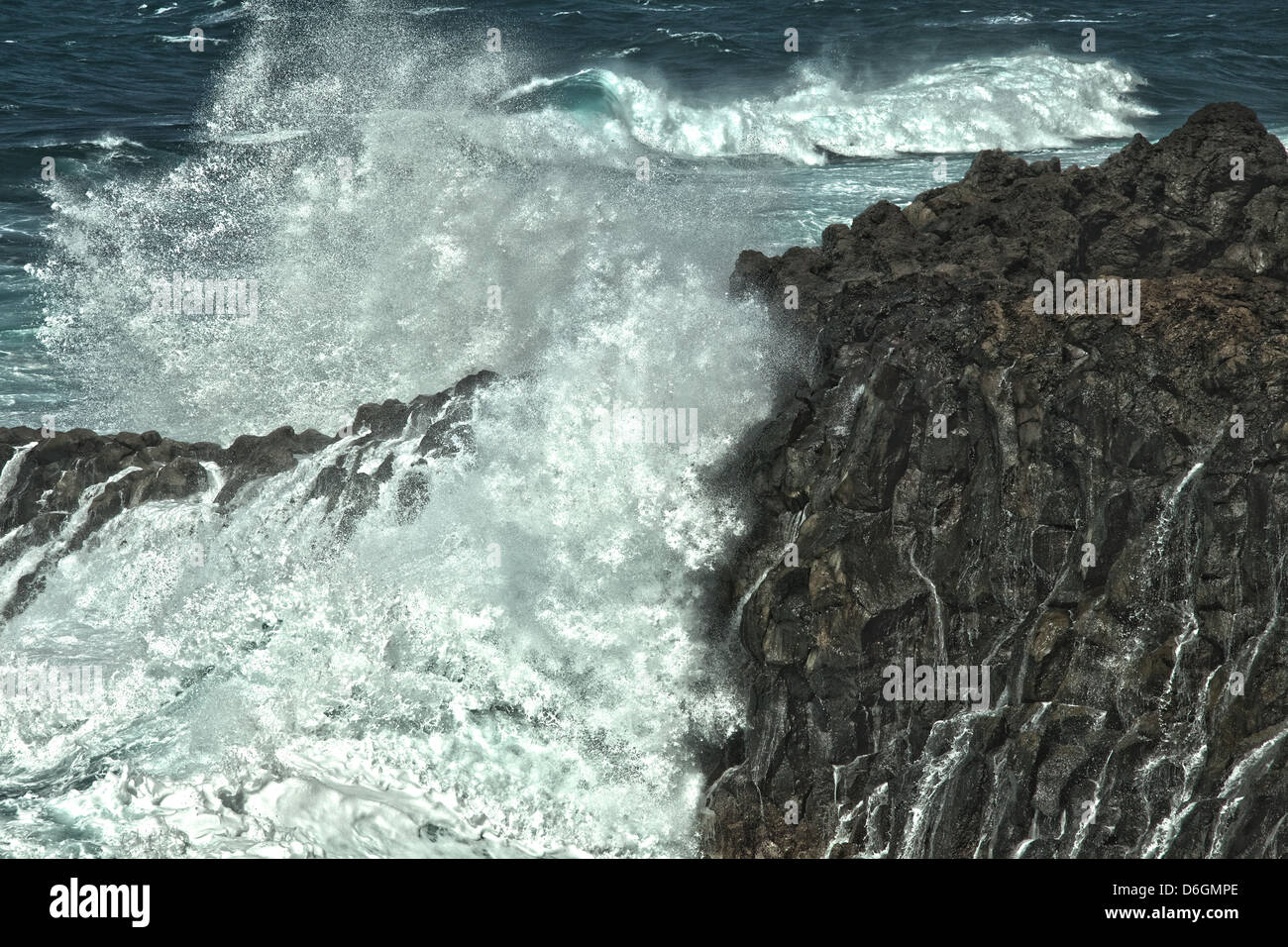 Waves splashing on rocky lava coast Stock Photo - Alamy