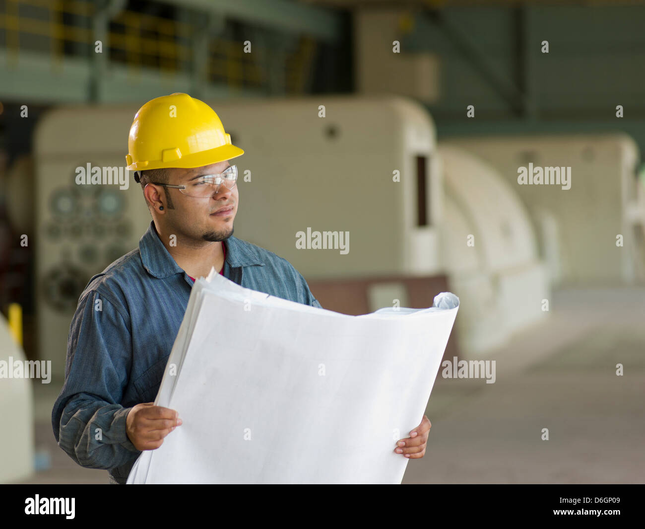 Engineer reading blueprints on site Stock Photo - Alamy
