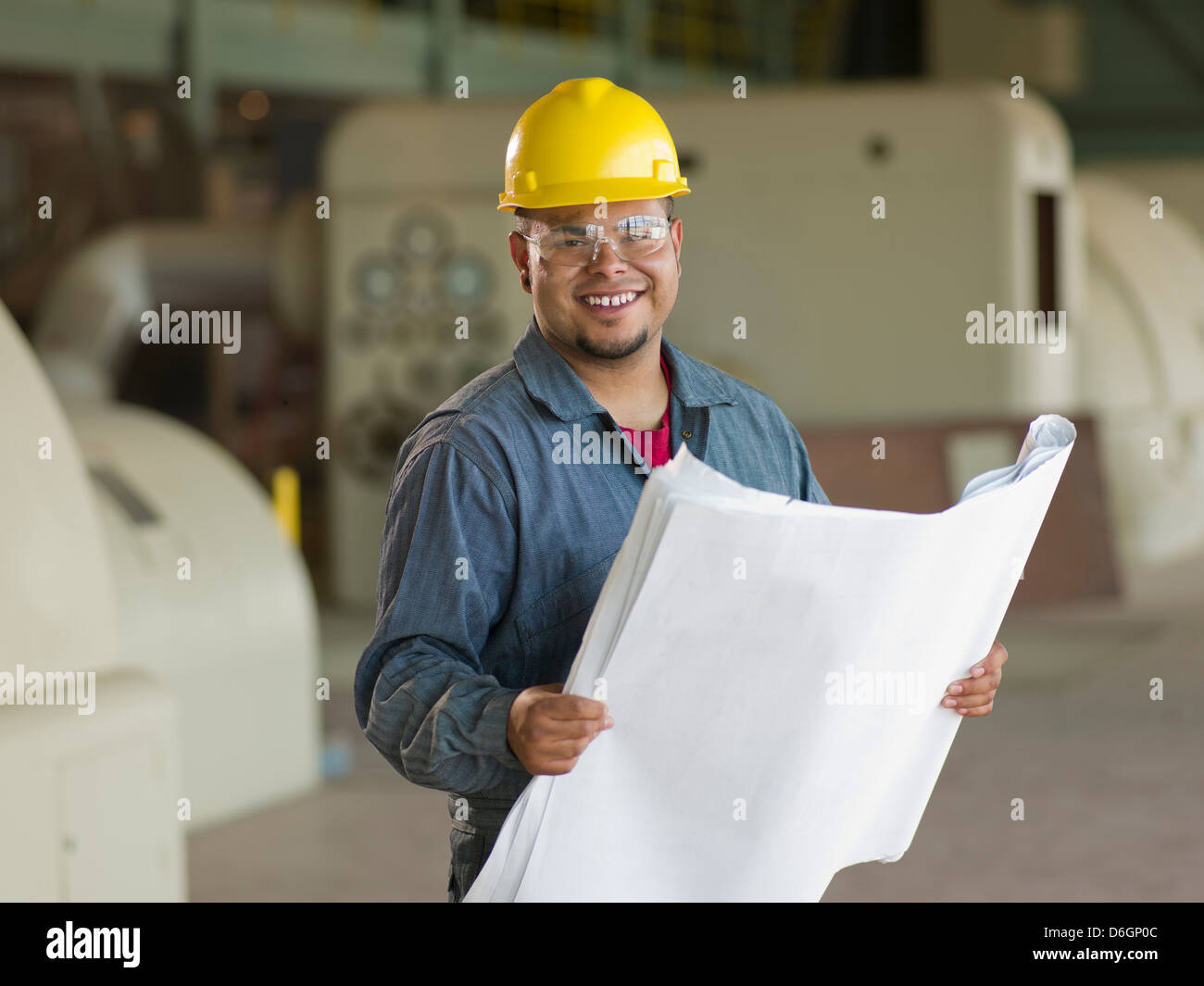 Engineer reading blueprints on site Stock Photo - Alamy