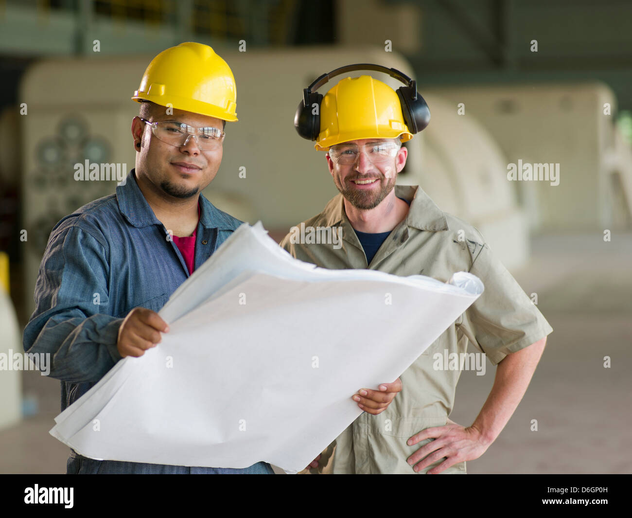 Engineers reading blueprints on site Stock Photo - Alamy