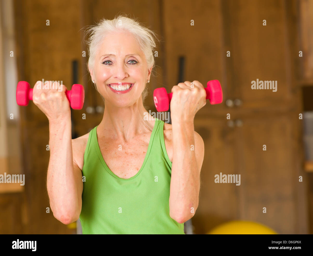 Older woman lifting weights at home Stock Photo - Alamy