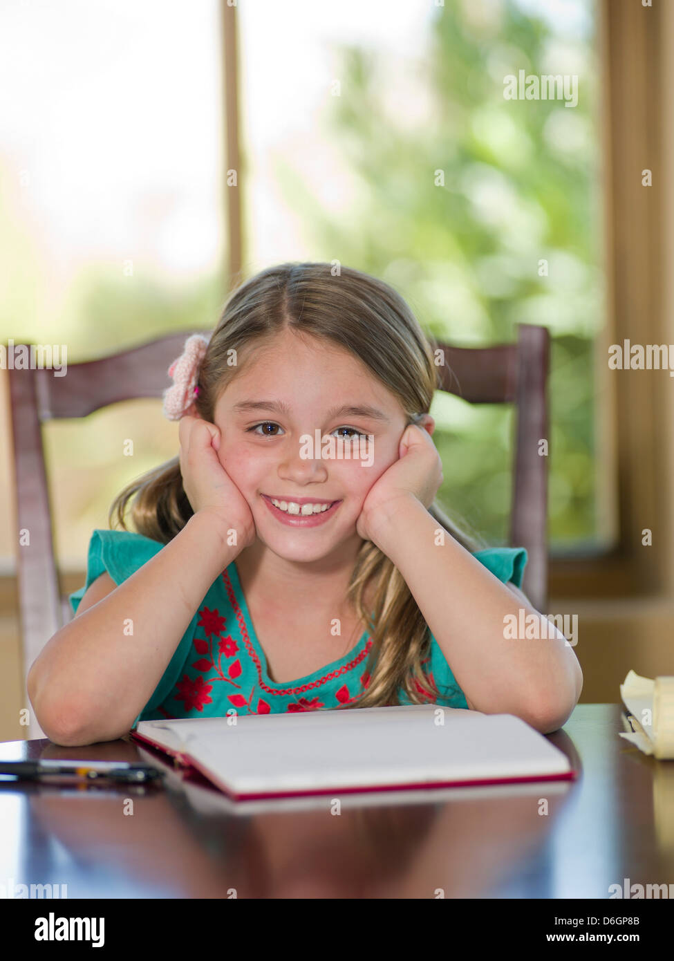Girl doing homework at table Stock Photo - Alamy
