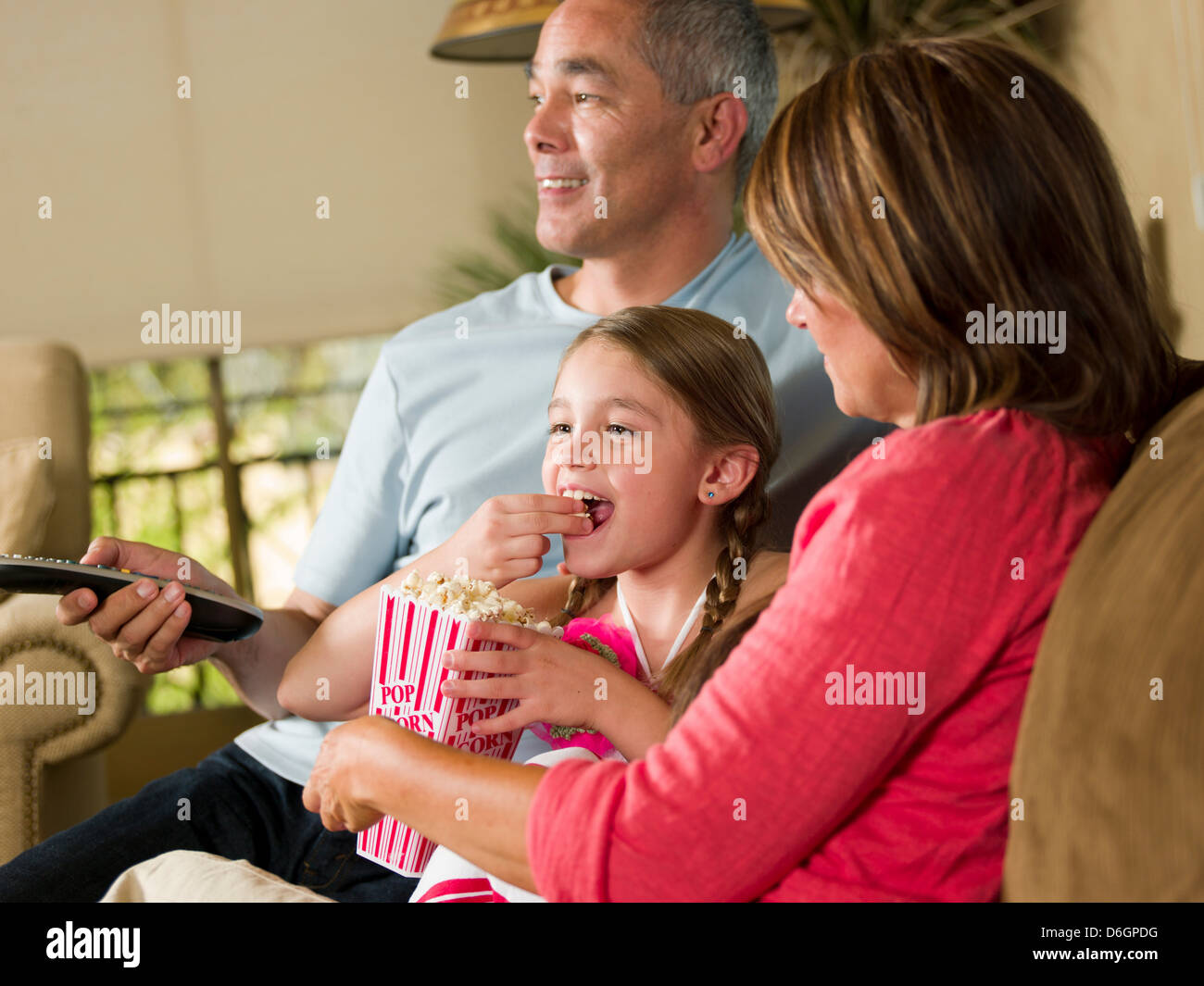 Family relaxing together on sofa Stock Photo - Alamy
