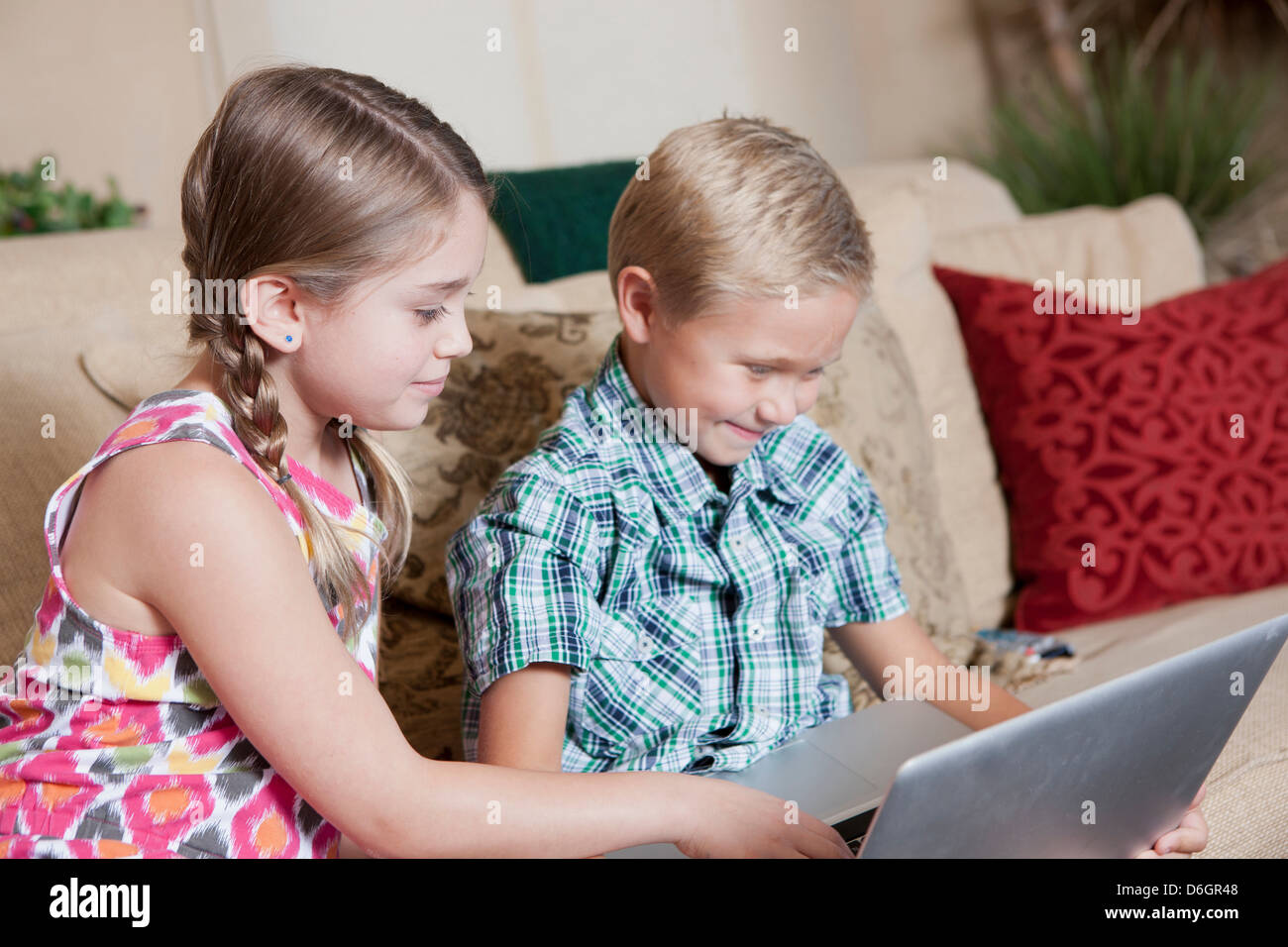 Children using laptop together on sofa Stock Photo - Alamy