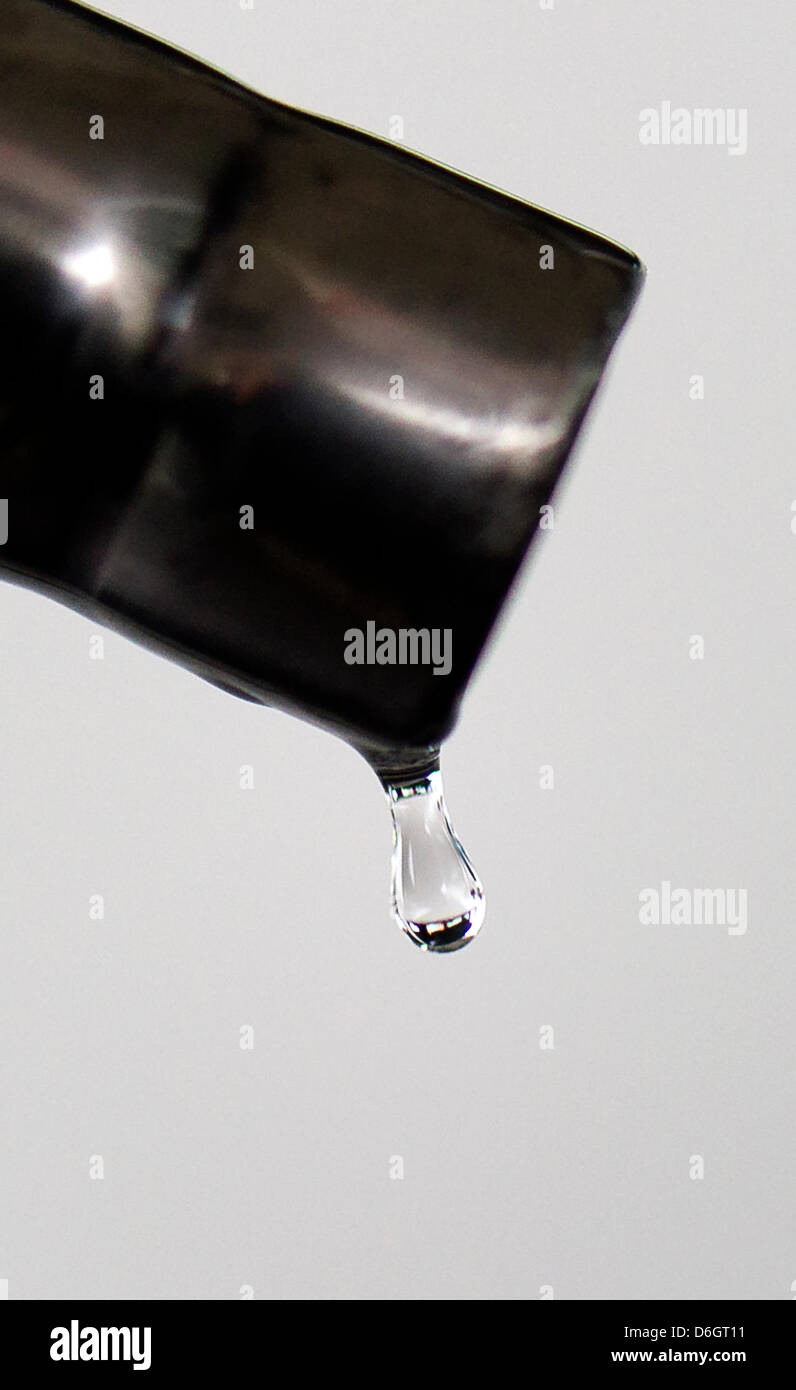 A drop of premium petrol hangs from a petrol pump at a petrol station ...