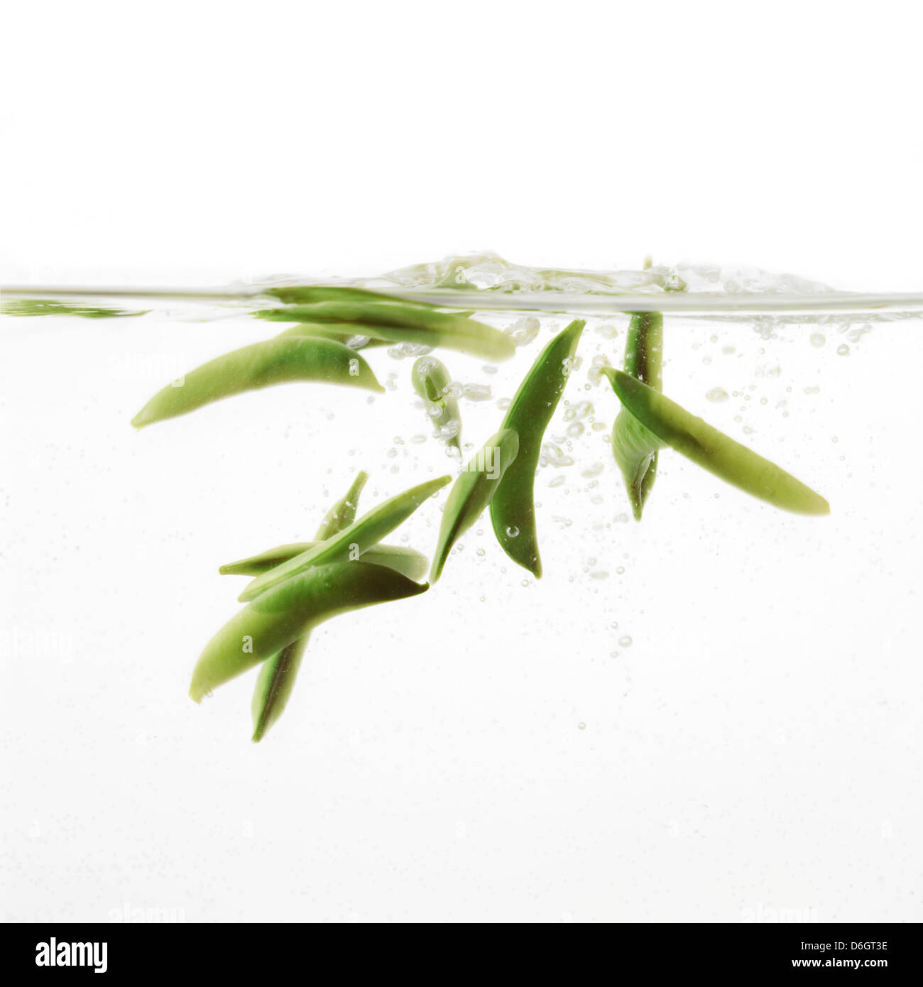 Peas in the Pod splashing into water Stock Photo - Alamy