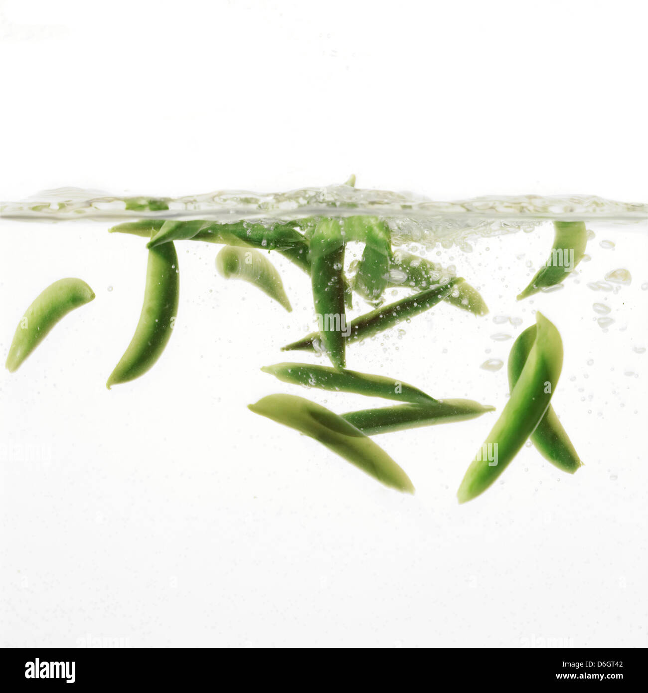 Peas in the Pod splashing into water Stock Photo - Alamy