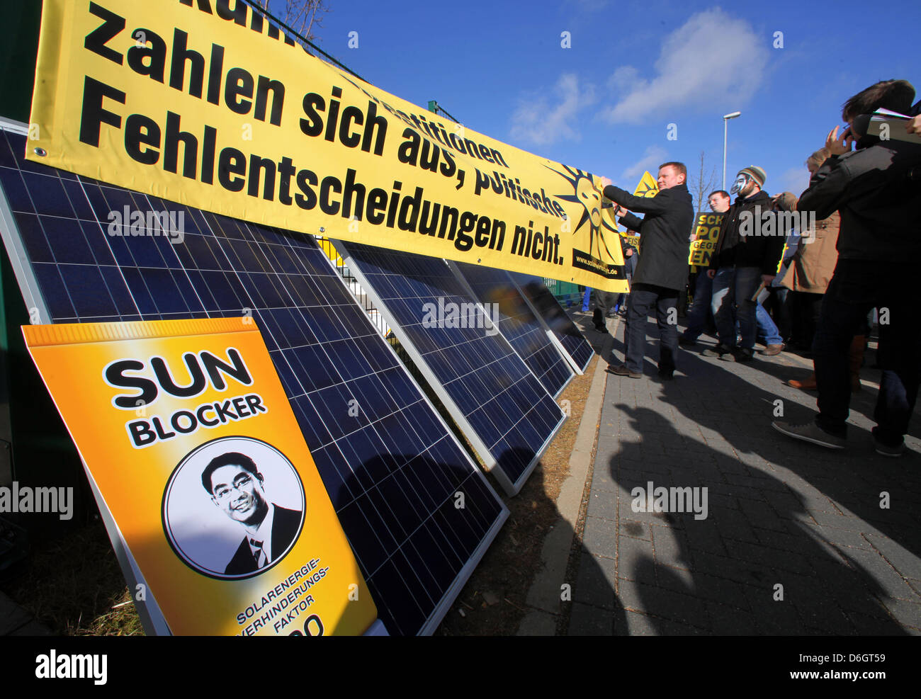 Pprotesters put up a banner during a protest by employees of the solar ...