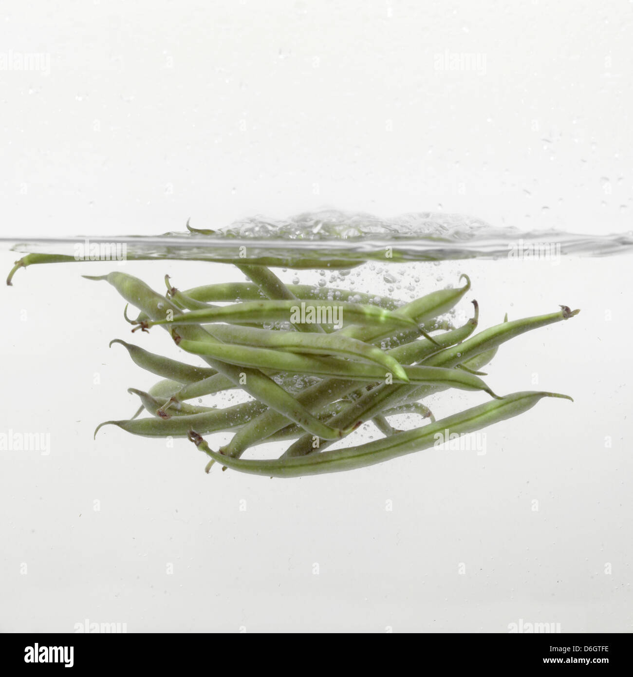 Green Beans splashing into water Stock Photo - Alamy