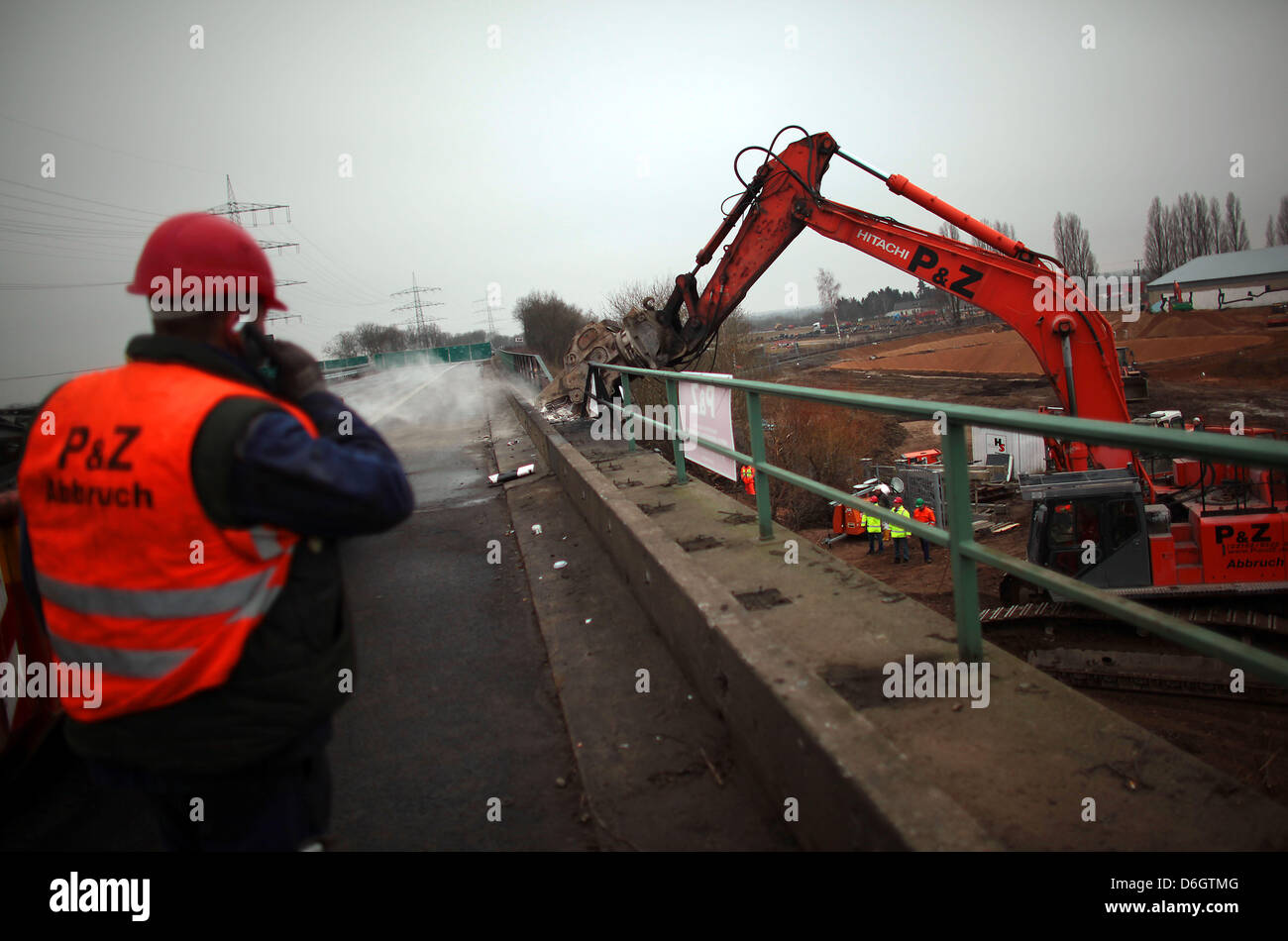 An excavator starts to demolish a bridge at the Autobahn 57 severely ...