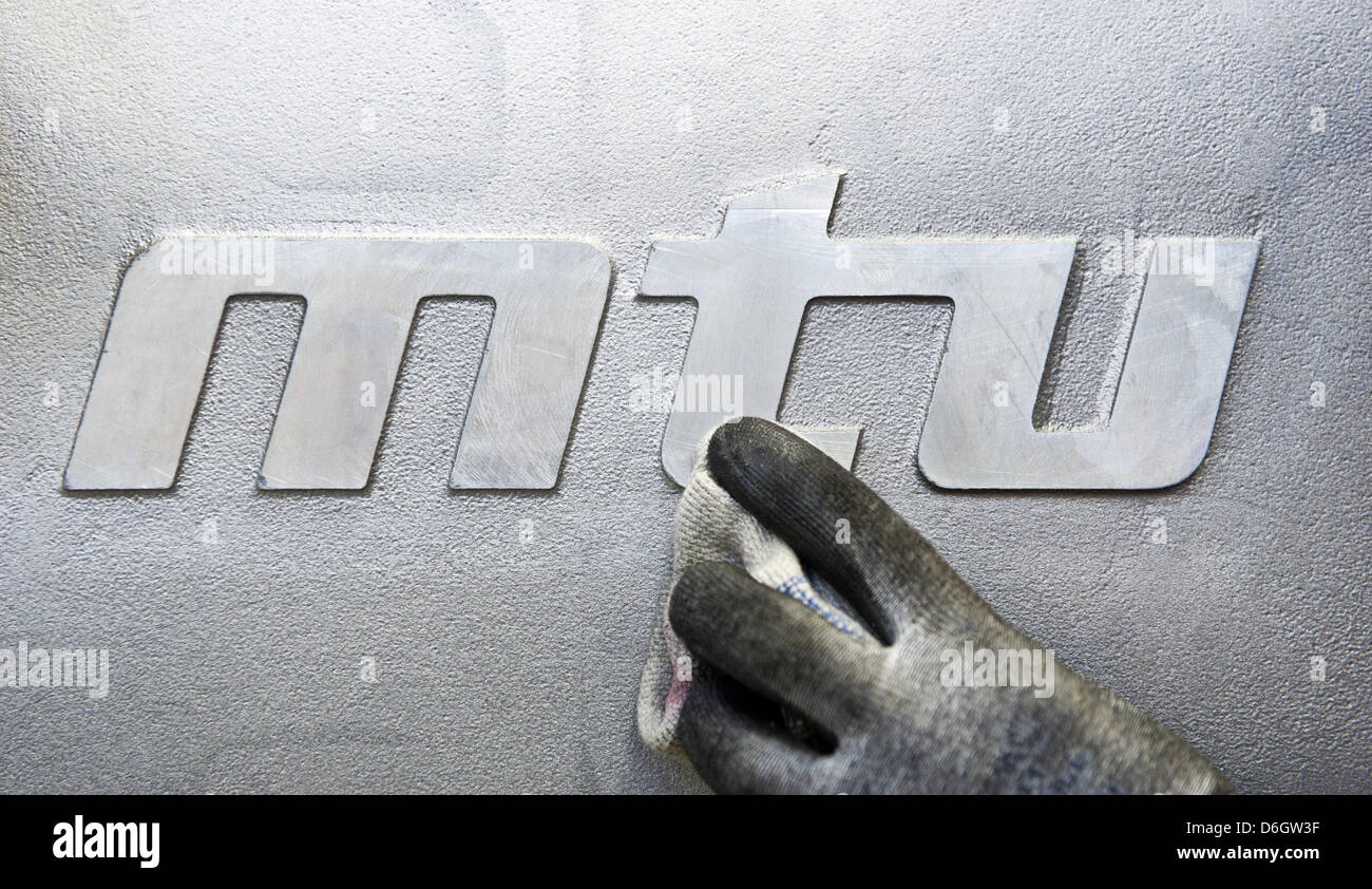 (ILLUSTRATION) An illustration shows a hand polishing the MTU logo at ...