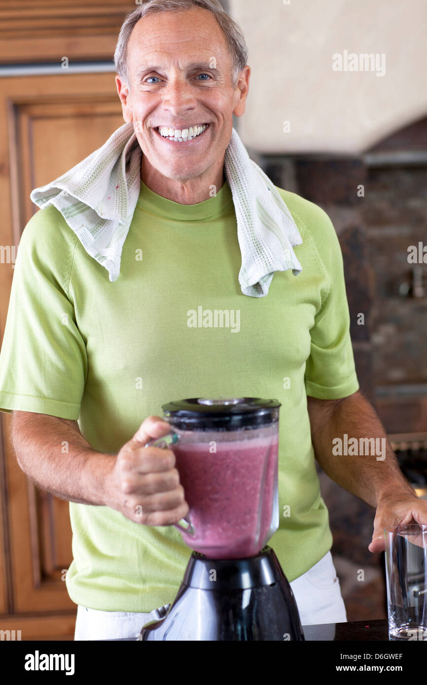 Older man making smoothie in kitchen Stock Photo - Alamy