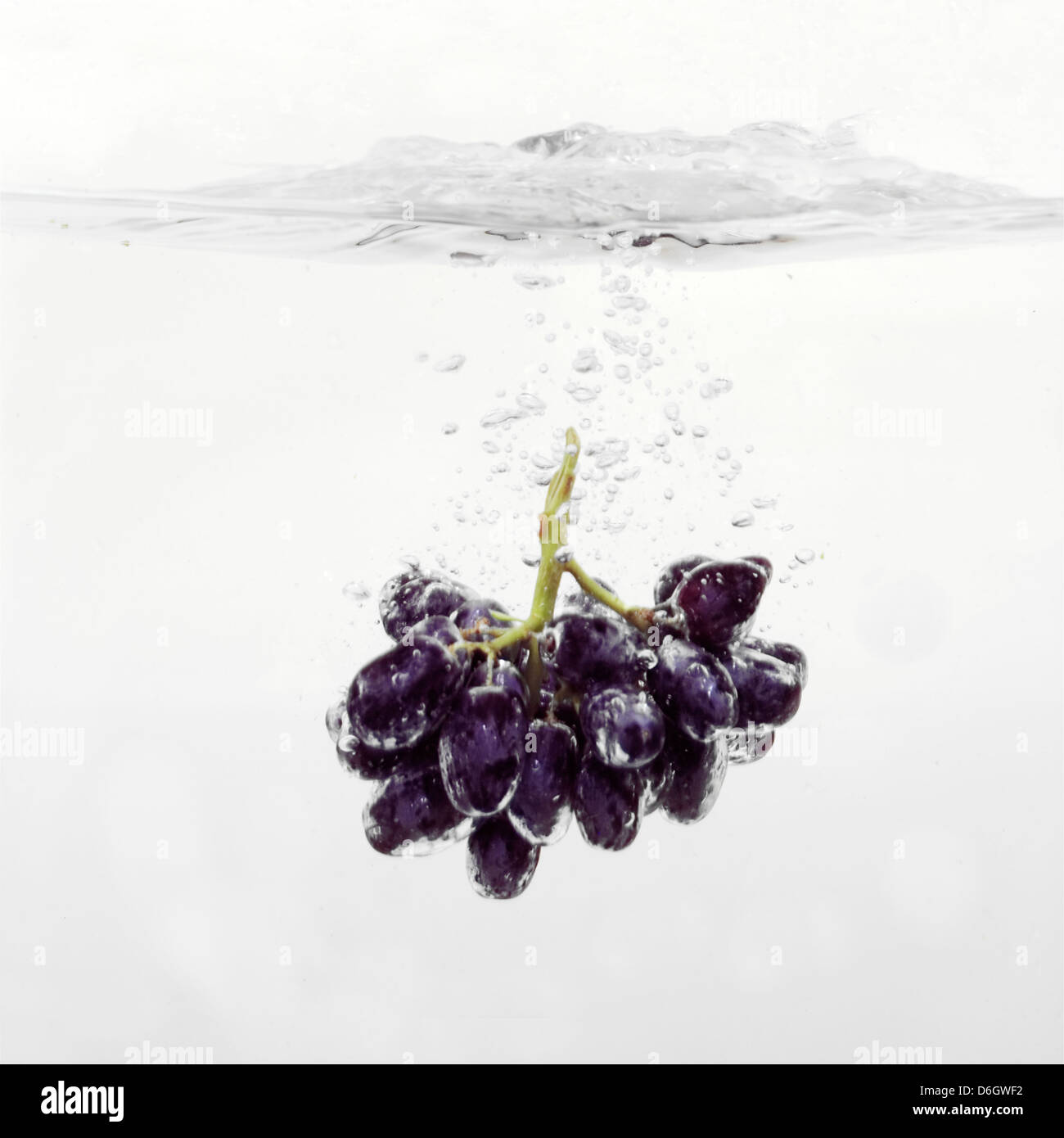 Bunch of Grapes splashing into water Stock Photo - Alamy