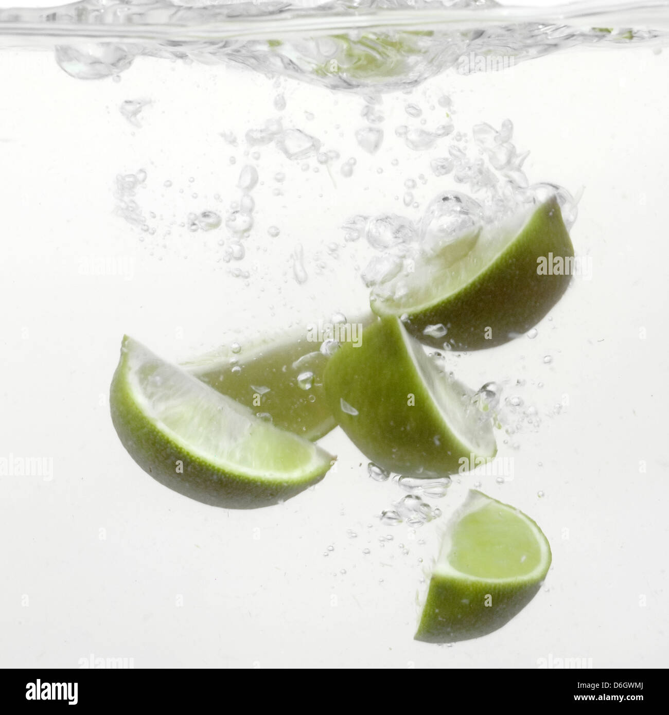 Lime wedges splashing into water Stock Photo - Alamy